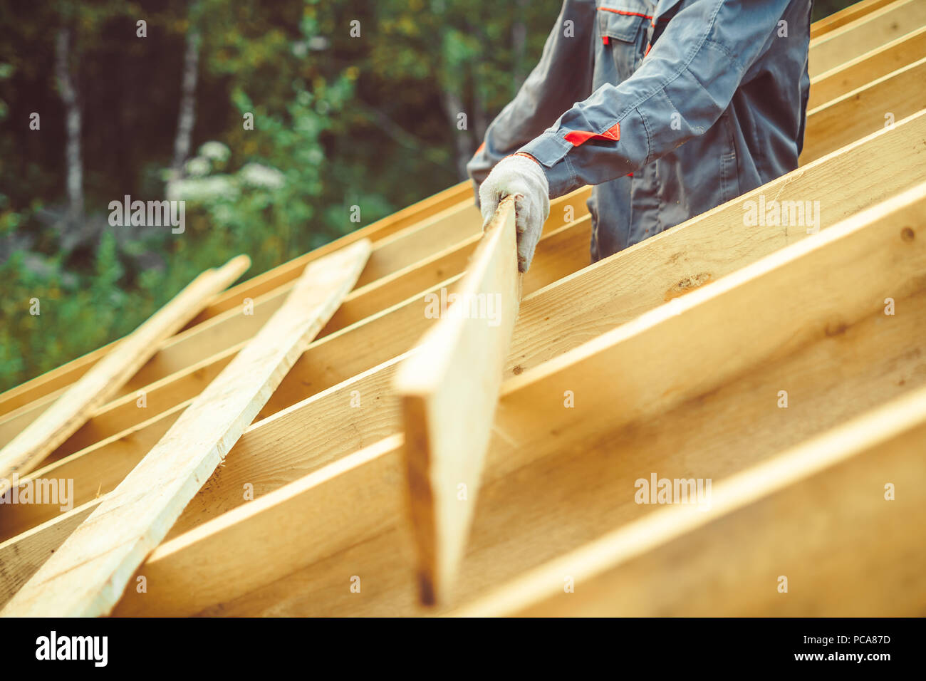 worker roofer builder working on roof structure on construction site ...