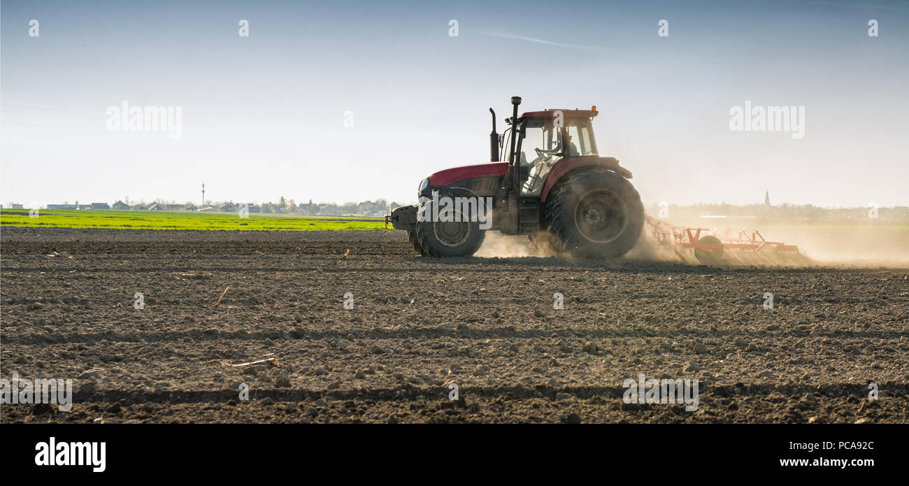 Tractor preparing land for sowing Stock Photo - Alamy