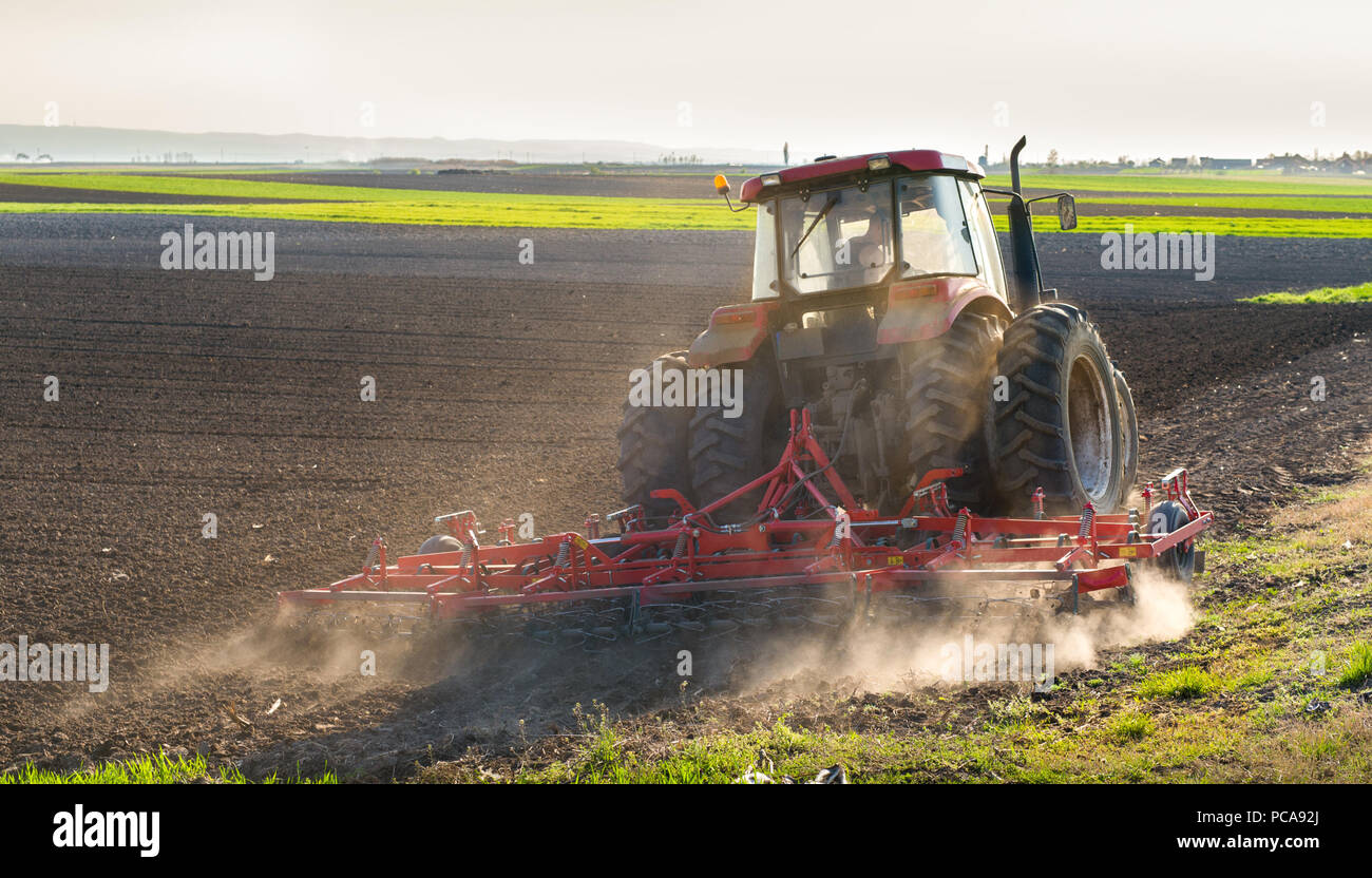 Tractor preparing land for sowing Stock Photo - Alamy