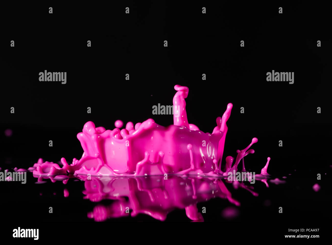 Magenta, pink paint, ink splash on black background Stock Photo - Alamy