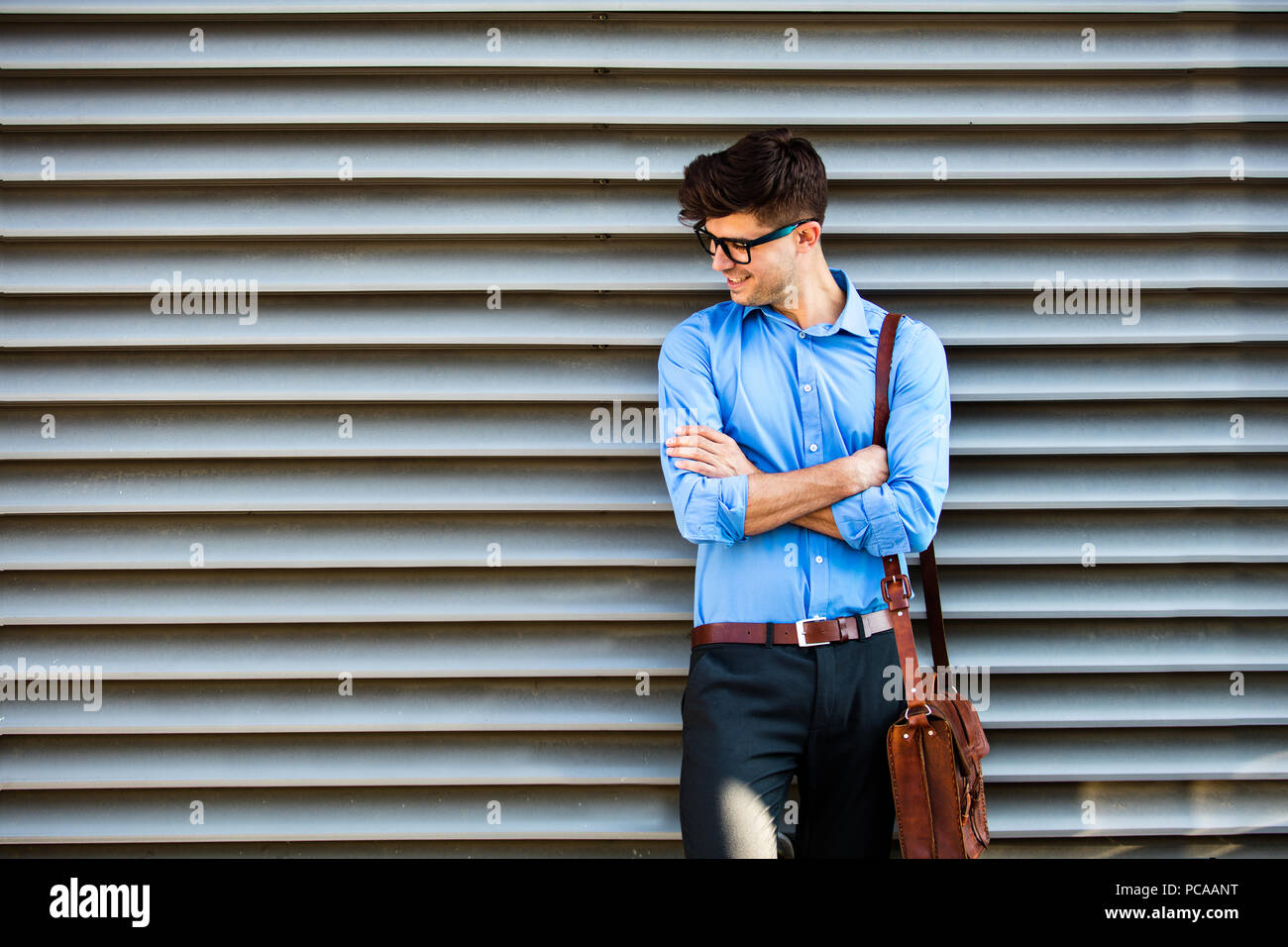 young office man waiting against a wall for something or someone, in ...