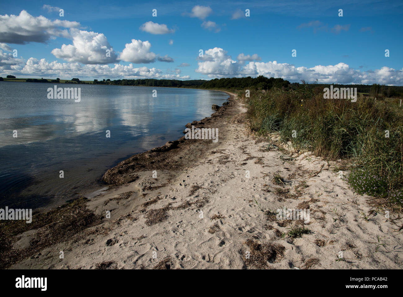 A narrow sandy and rocky beach stretches along the Bay of Stresow in ...