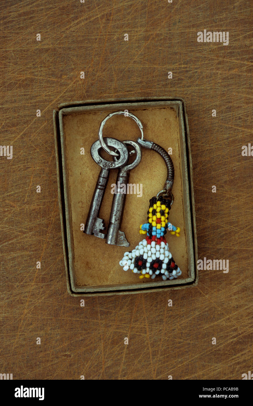 Two small tarnished silver keys attached to keyring with beaded model ...