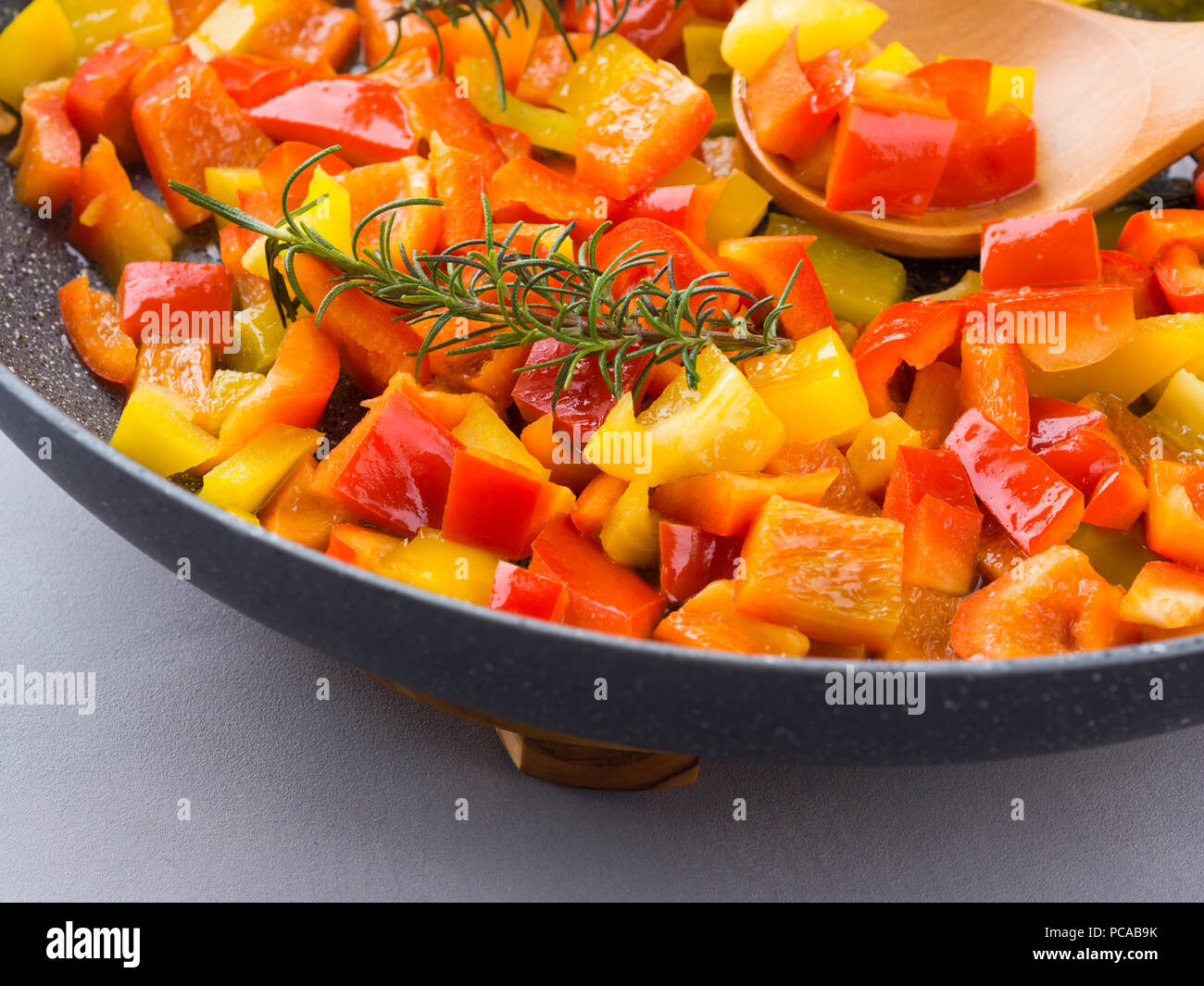 Cooking bell peppers with rosemary in frying pan Stock Photo - Alamy
