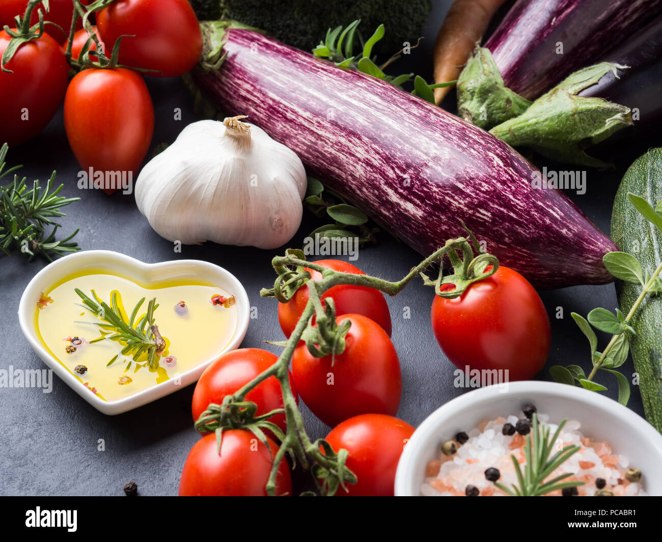 Mix of raw vegetables with salt, spices on dark background. Clean ...
