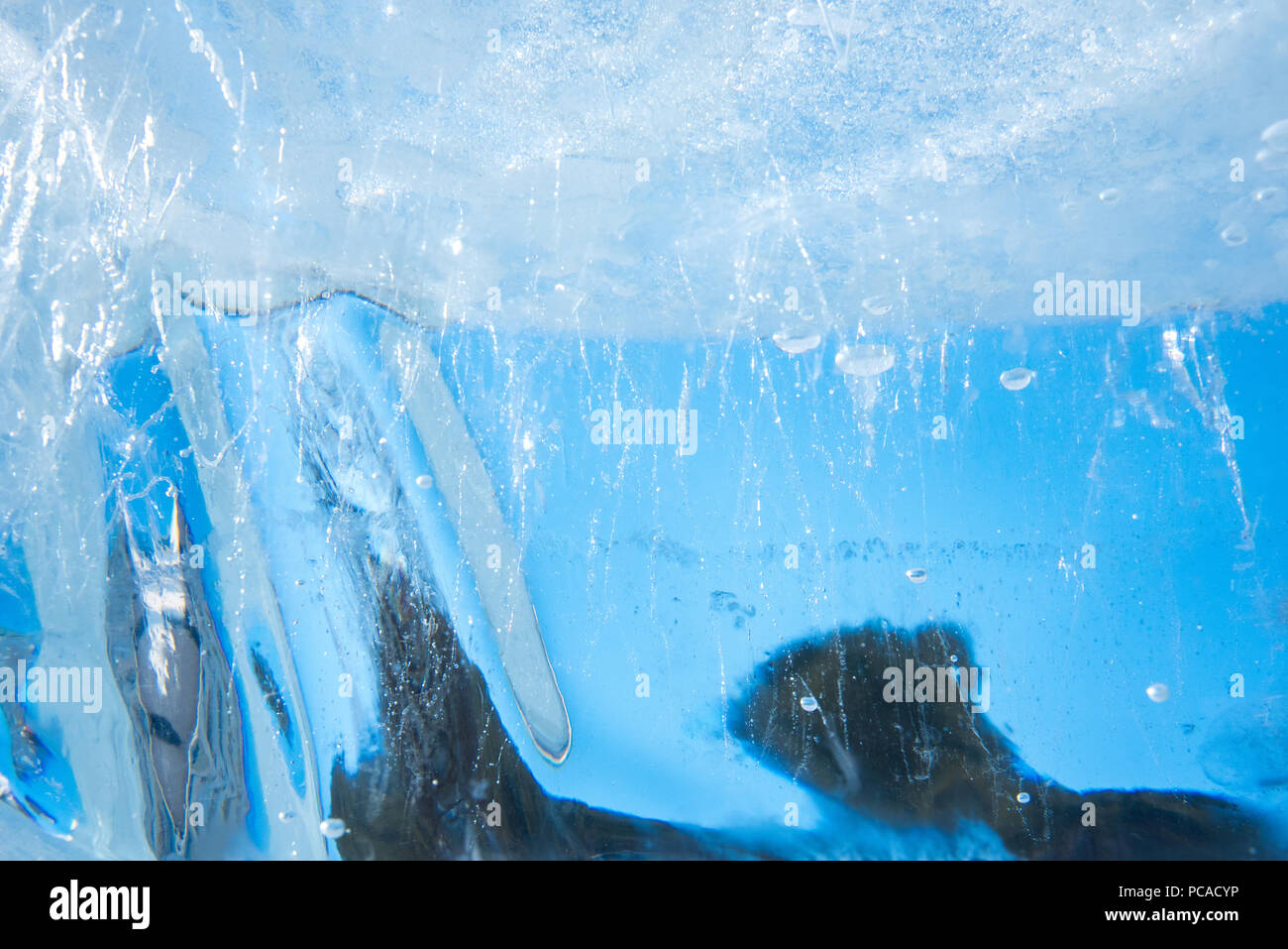 Beautiful abstract blue texture of transparent winter ice with rainbow ...