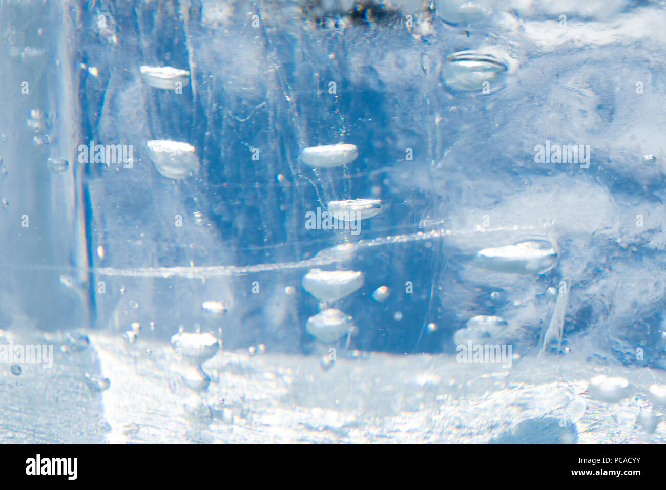 Beautiful abstract blue texture of transparent winter ice with rainbow ...