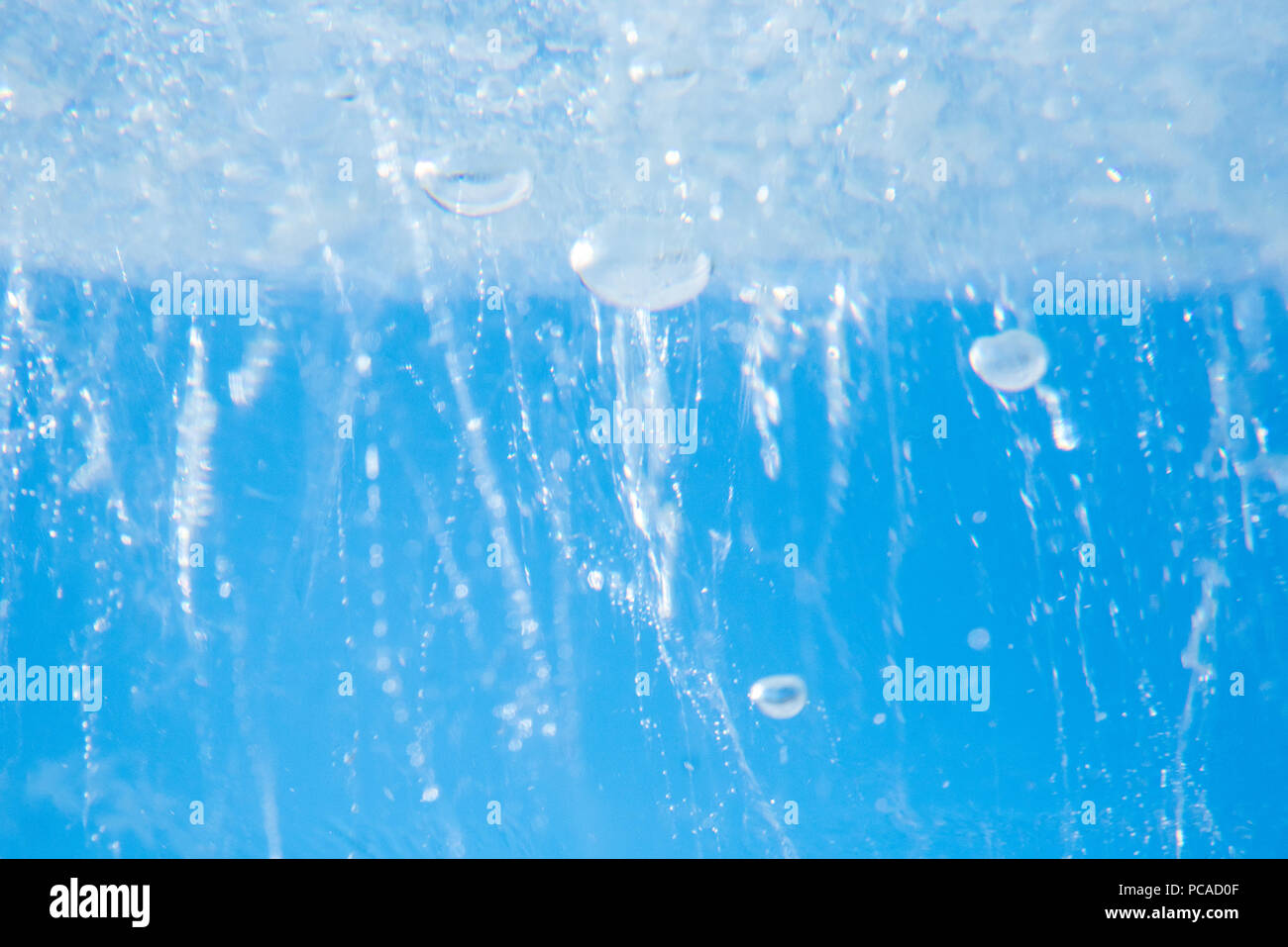 Beautiful abstract blue texture of transparent winter ice with rainbow ...