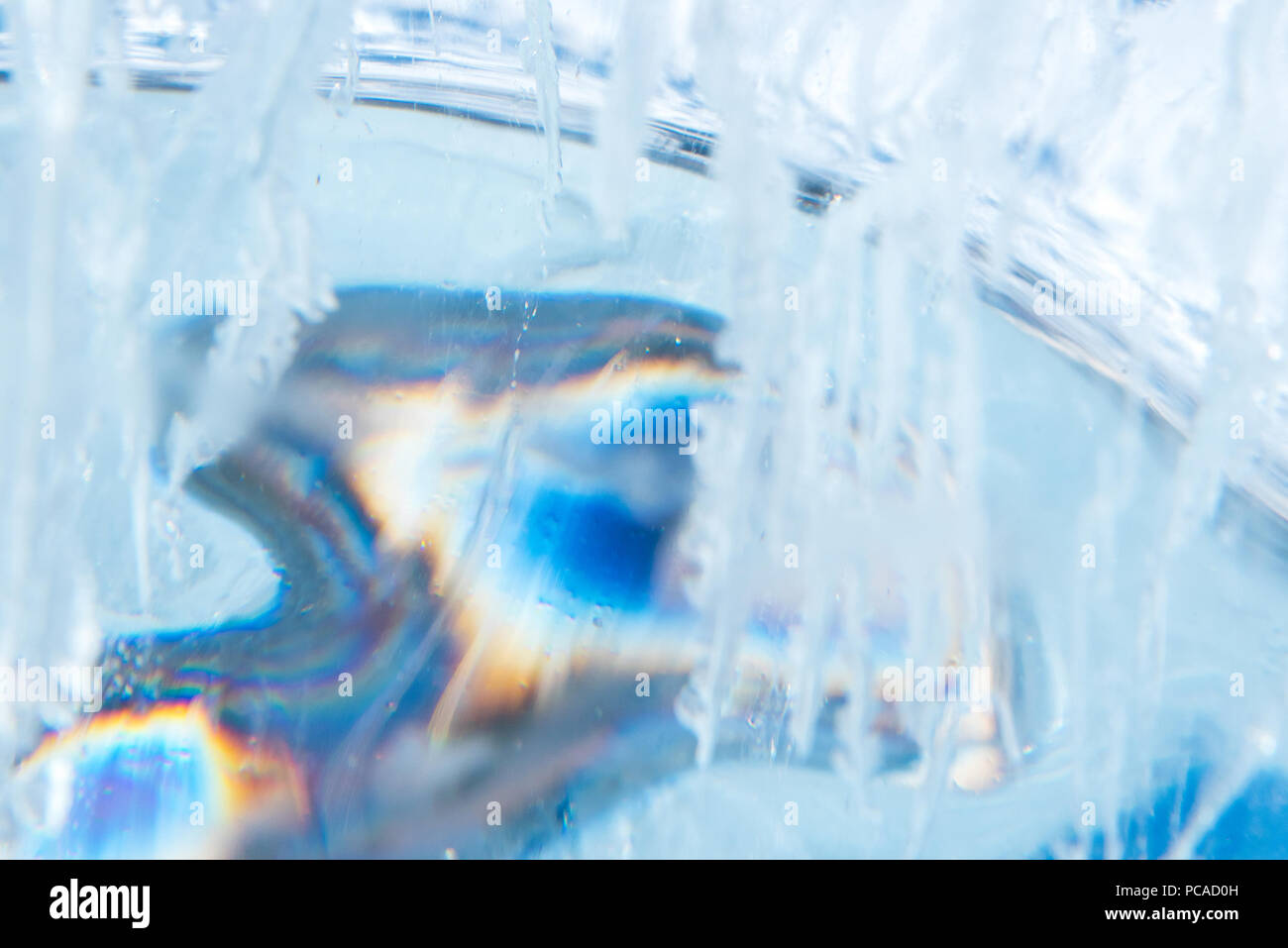 Beautiful abstract blue texture of transparent winter ice with rainbow ...