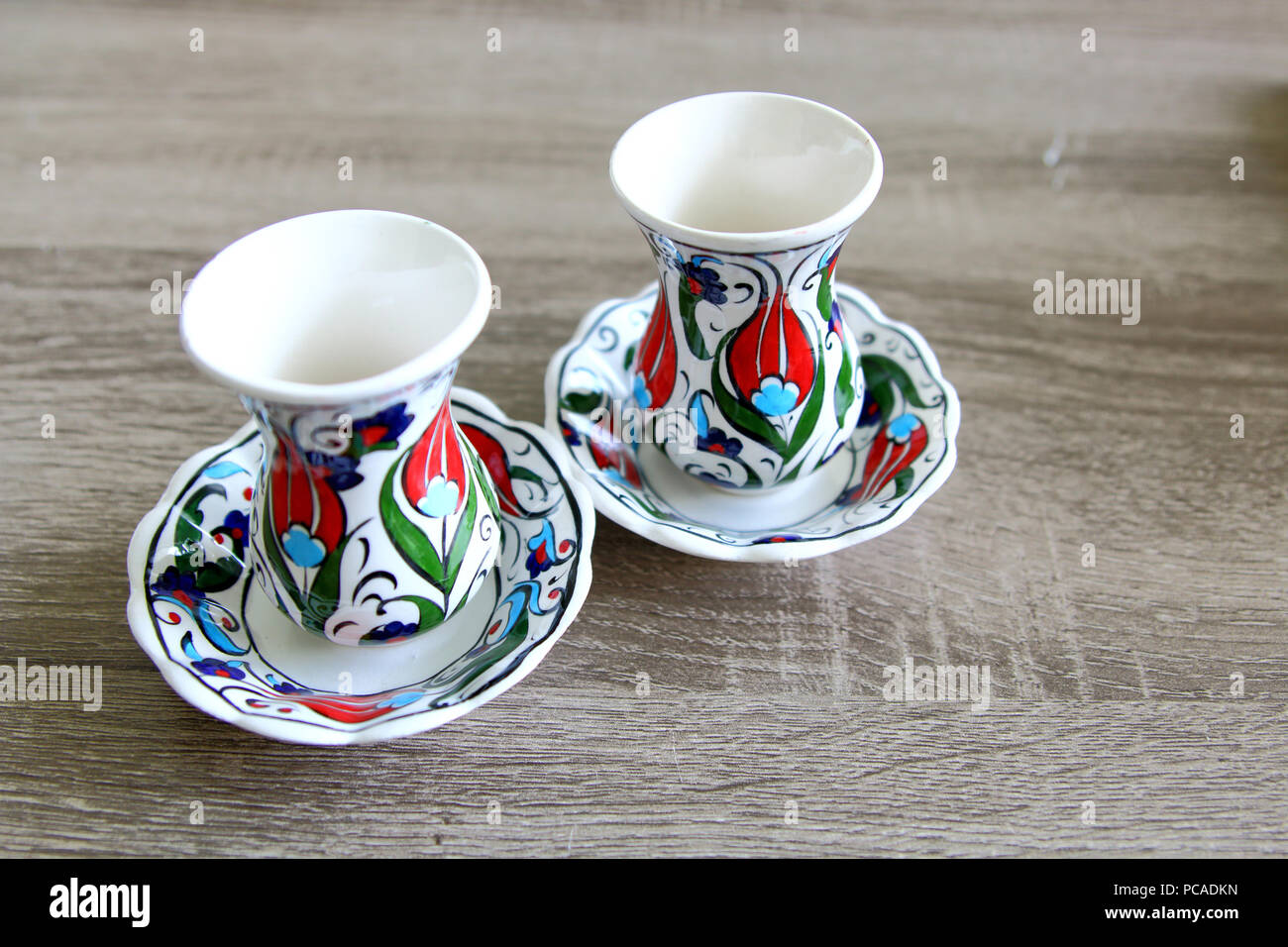 turkish tea or coffee cups and small plates over a light wood grey ...