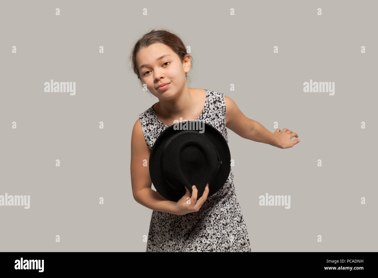 Gallant girl taking off her hat, portrait in studio Stock Photo - Alamy