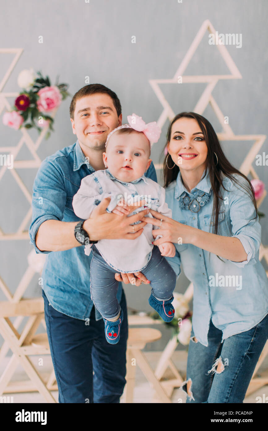 Smiling parents are swinging and playing with their baby at lovely ...