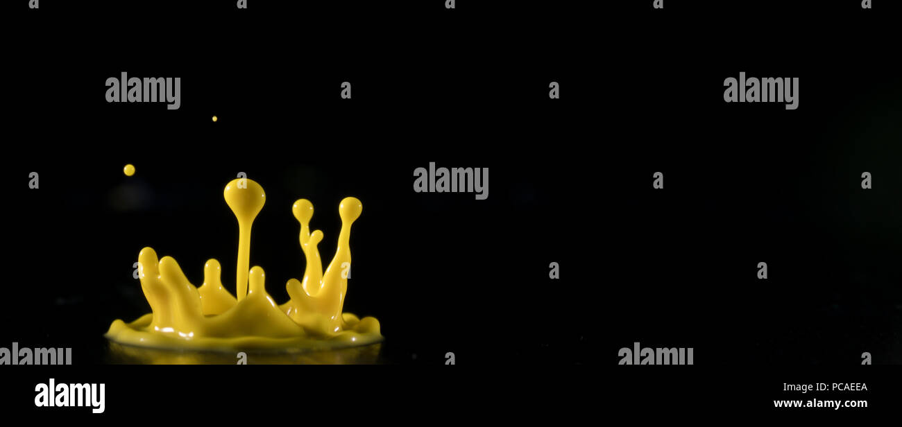 Yellow paint, ink splash on black background Stock Photo - Alamy