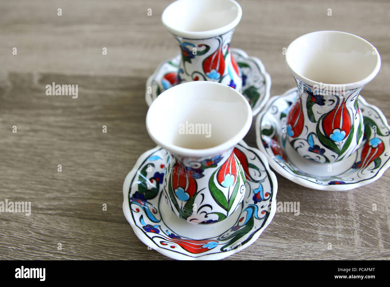 turkish tea or coffee cups and small plates over a light wood grey ...
