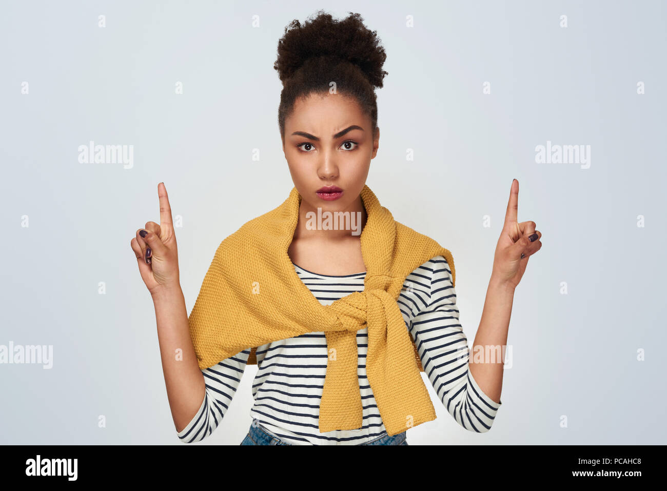Young woman studio isolated in white pointing up with two hands Stock ...