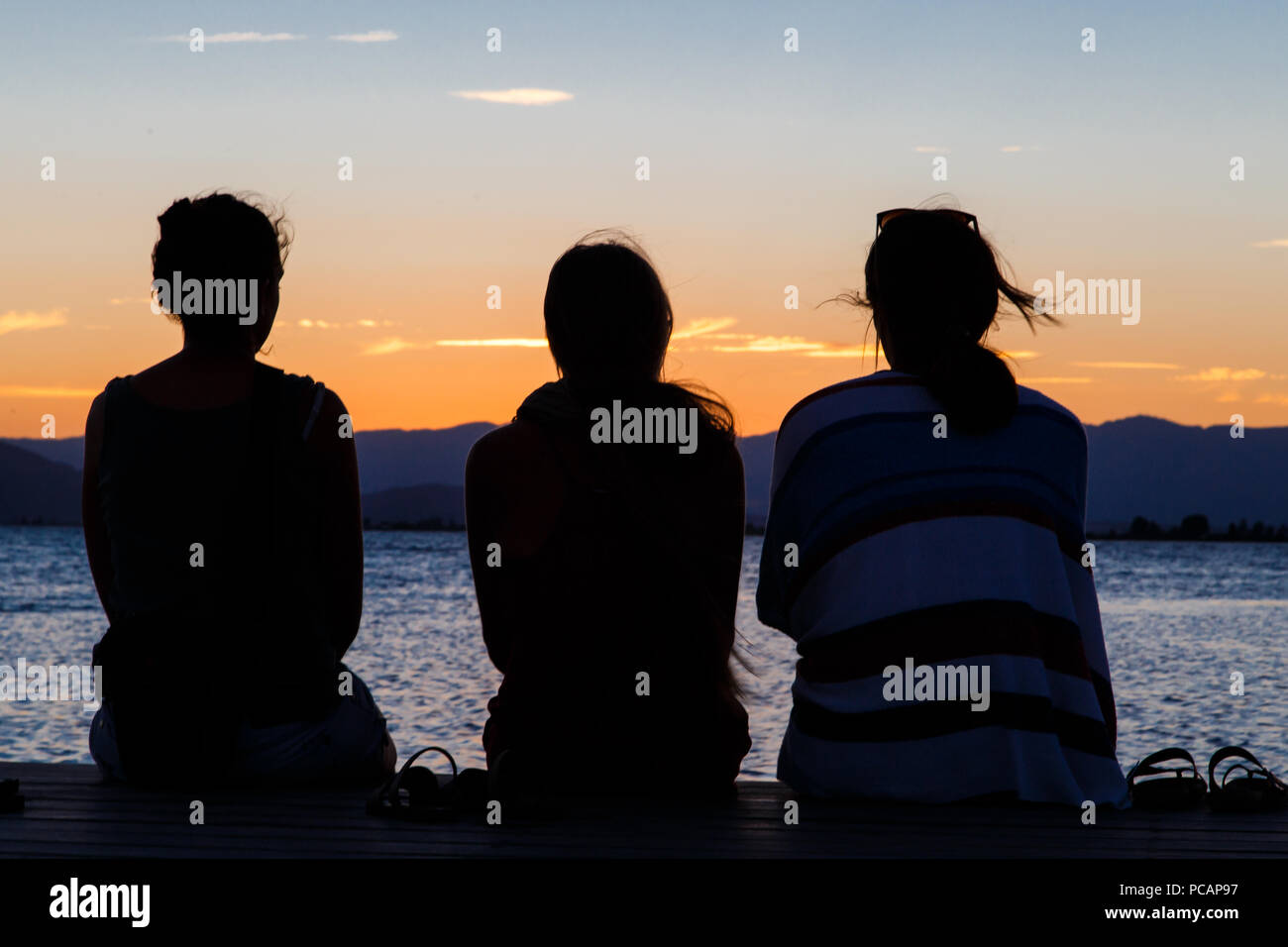 people on their backs watching sunset on the beach Stock Photo - Alamy