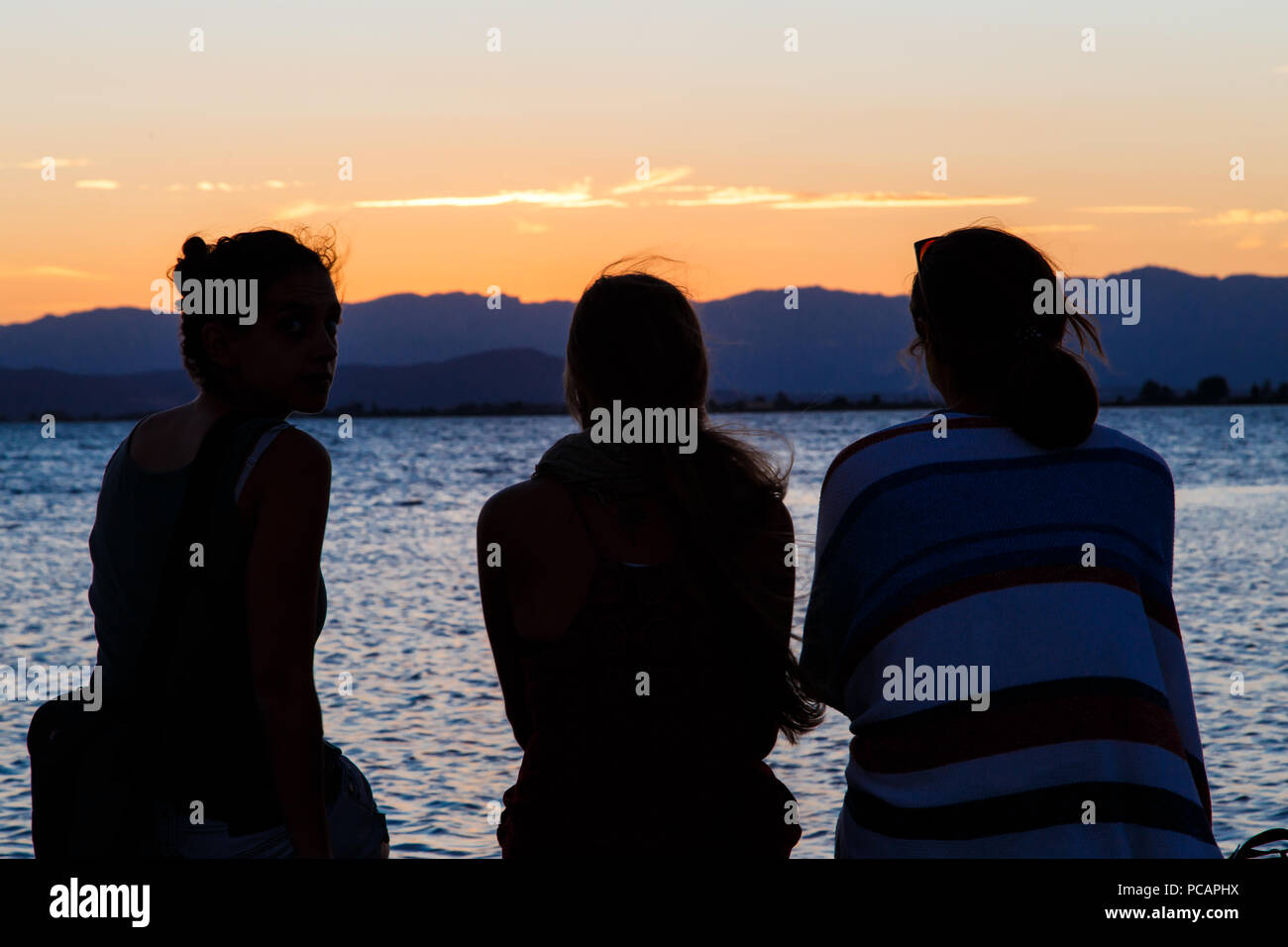 people on their backs watching sunset on the beach Stock Photo - Alamy