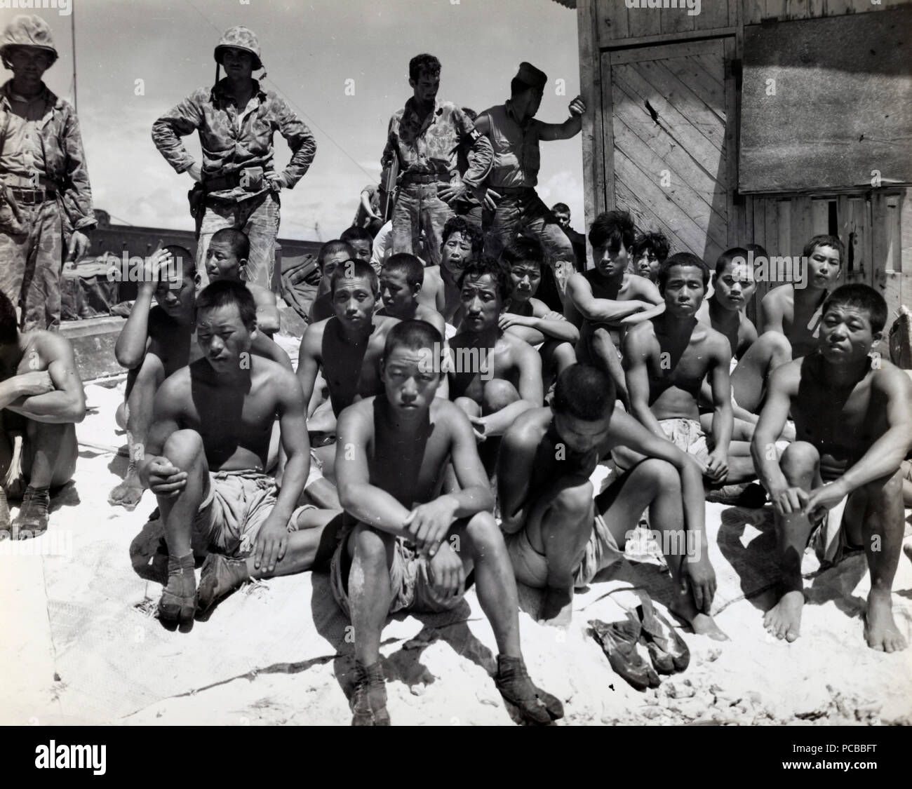 Prisoners at end of Tarawa pier awaiting transport to a ship for ...