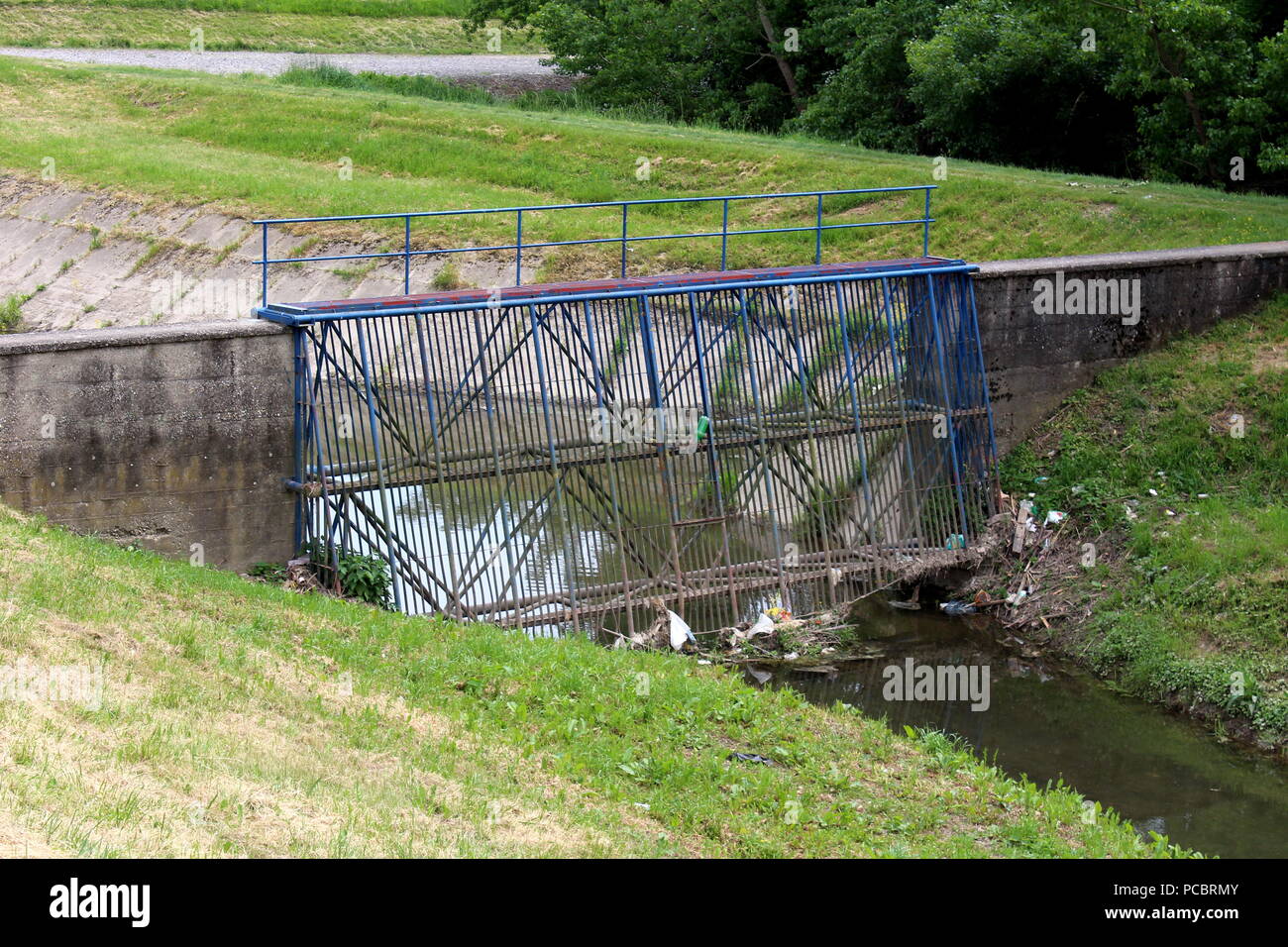 Protection gate in old flood water relief canal made from metal pipes ...