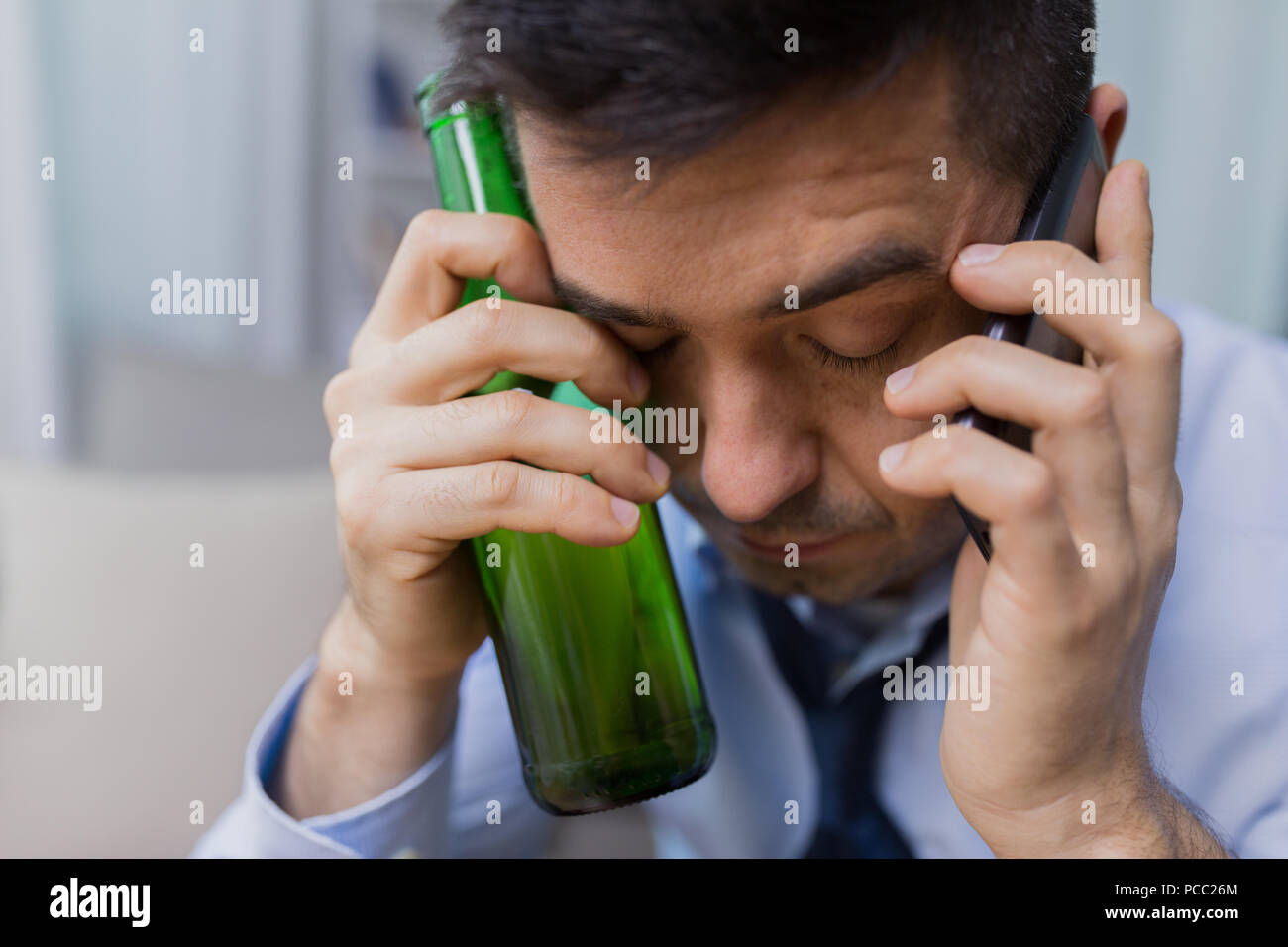 man with bottle of alcohol calling on smartphone Stock Photo - Alamy
