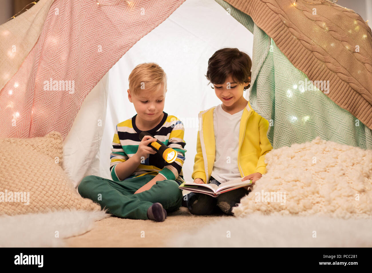 happy boys reading book in kids tent at home Stock Photo - Alamy