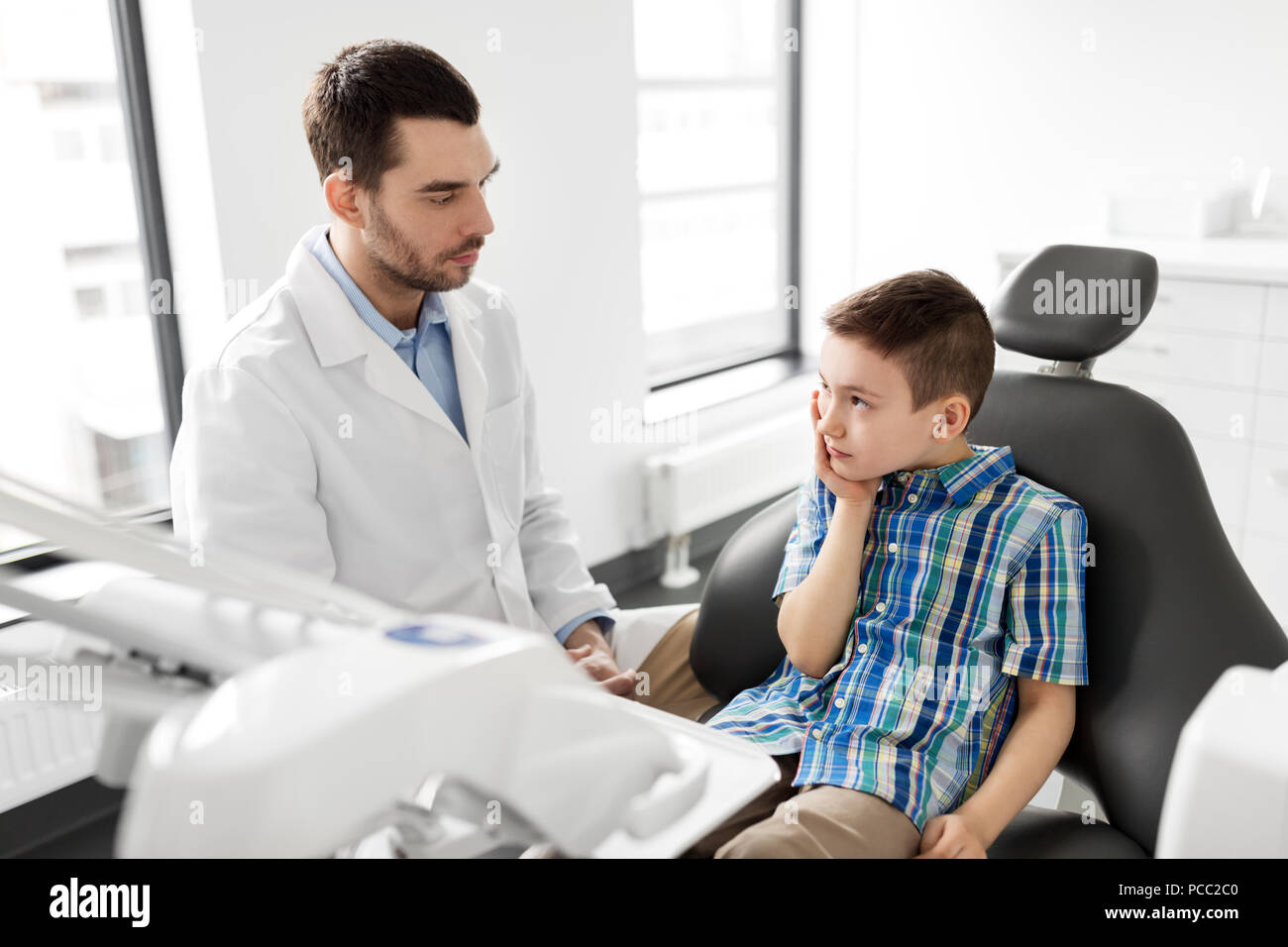 dentist with patient having toothache at clinic Stock Photo - Alamy