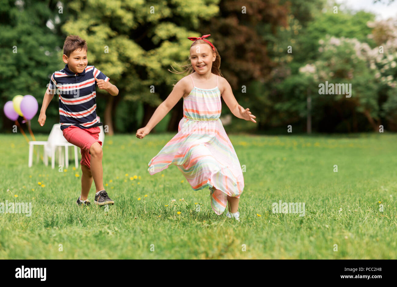happy kids playing tag game at birthday party Stock Photo - Alamy