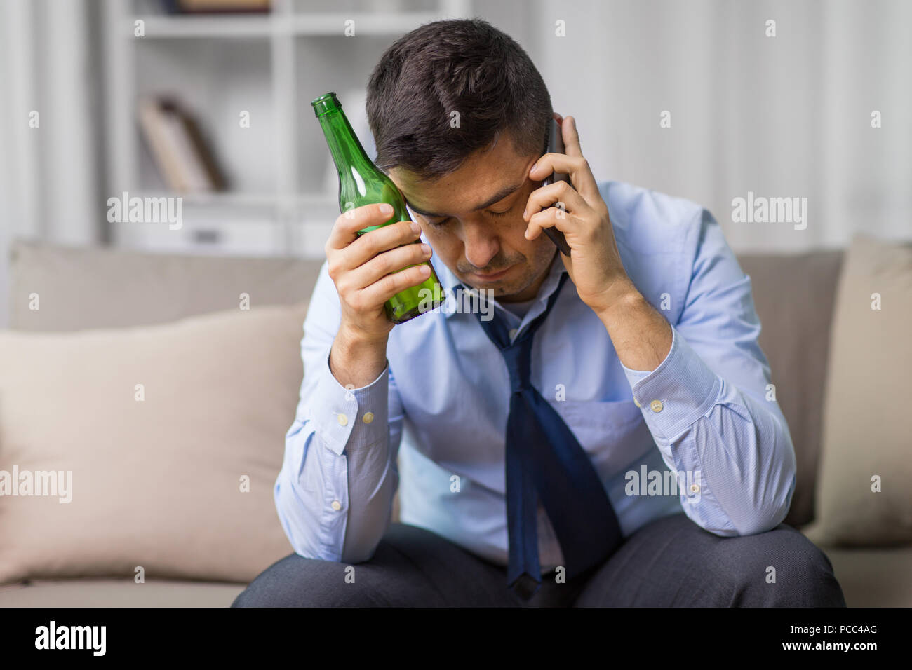 man drinking alcohol and calling on smartphone Stock Photo - Alamy