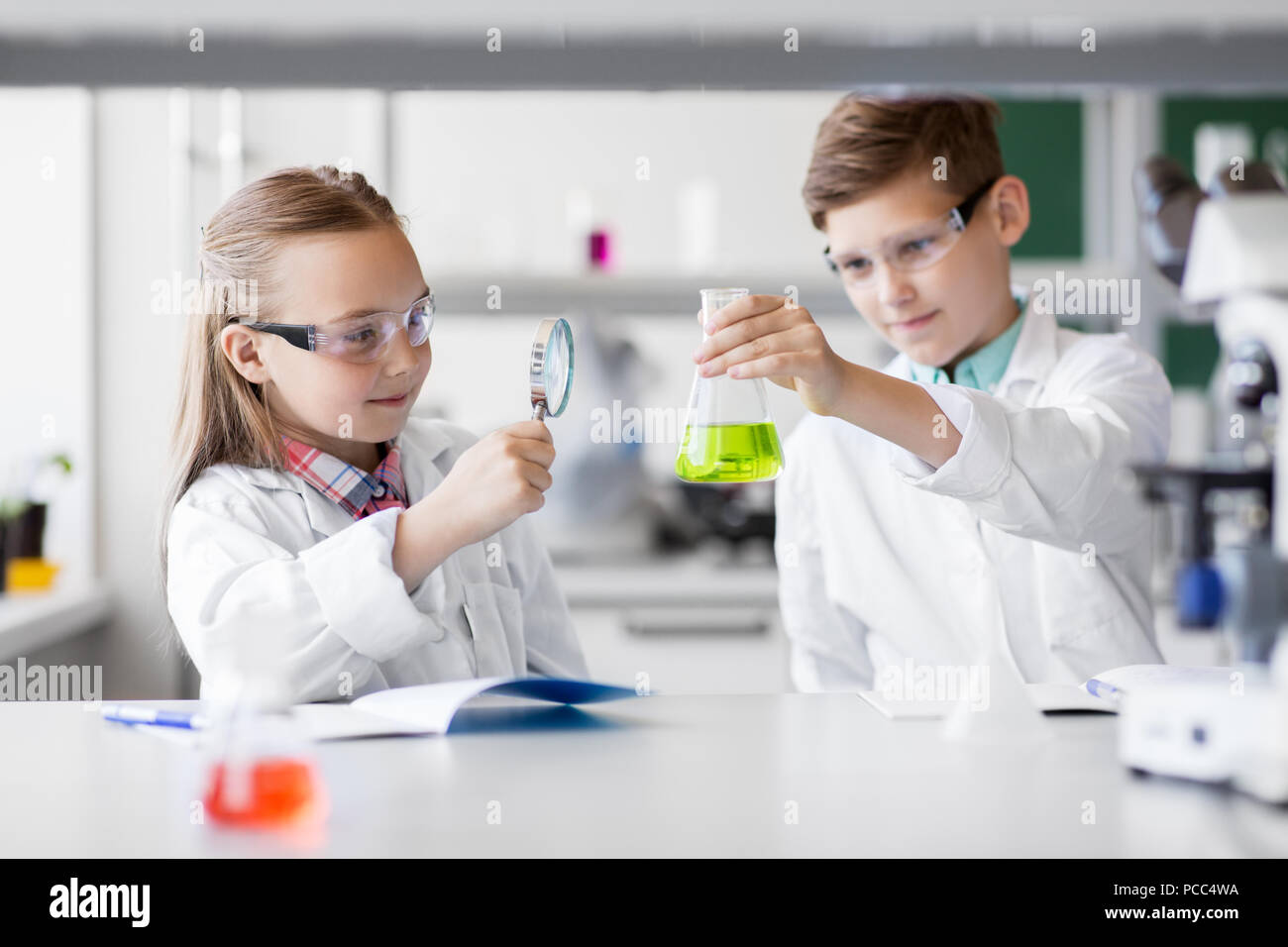 kids with flask and magnifier at chemistry class Stock Photo - Alamy