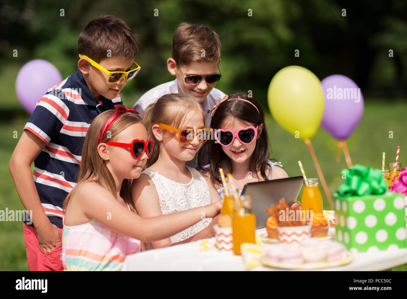 happy kids with tablet pc on birthday party Stock Photo - Alamy