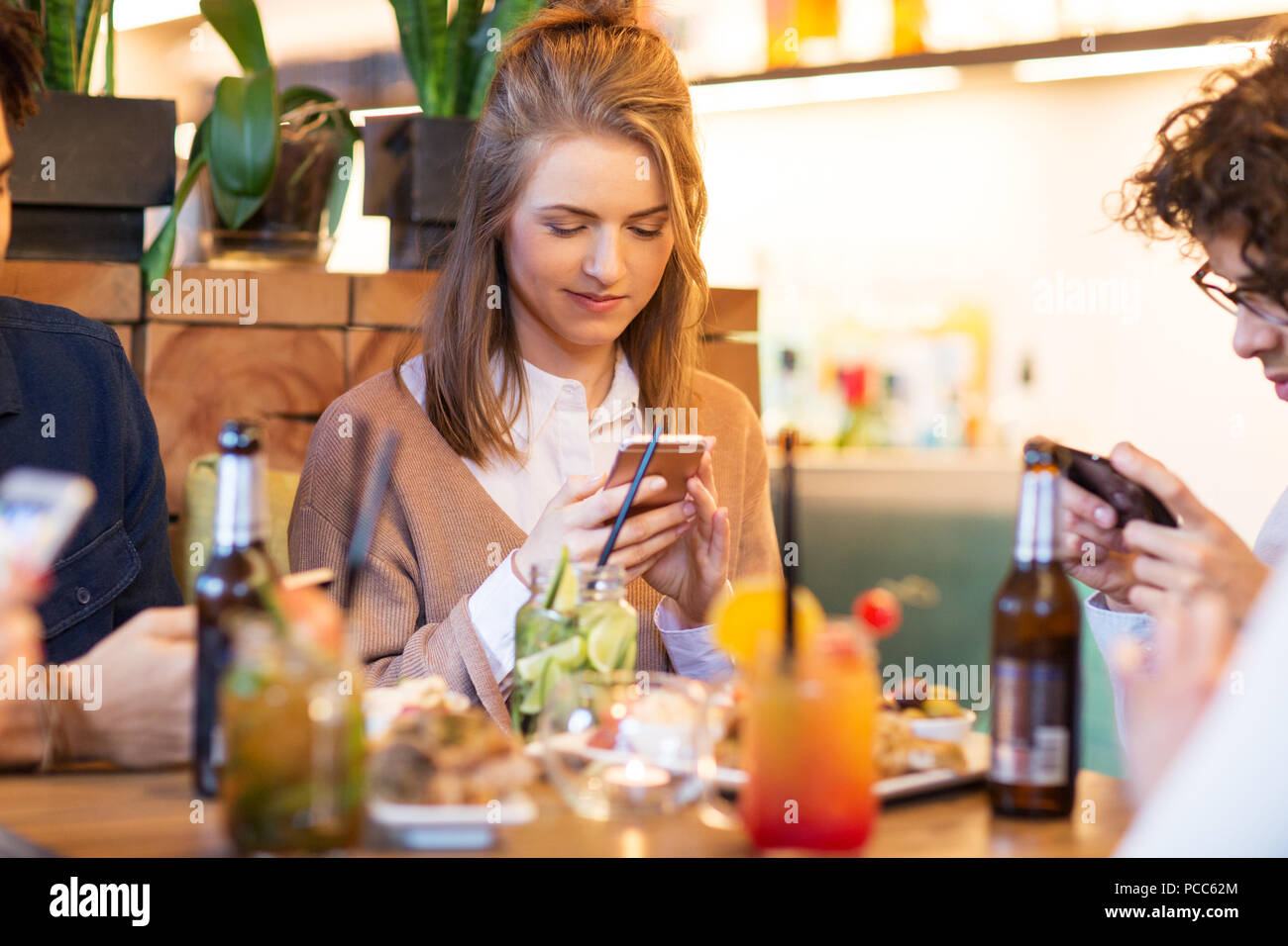 friends with smartphones eating at restaurant Stock Photo - Alamy