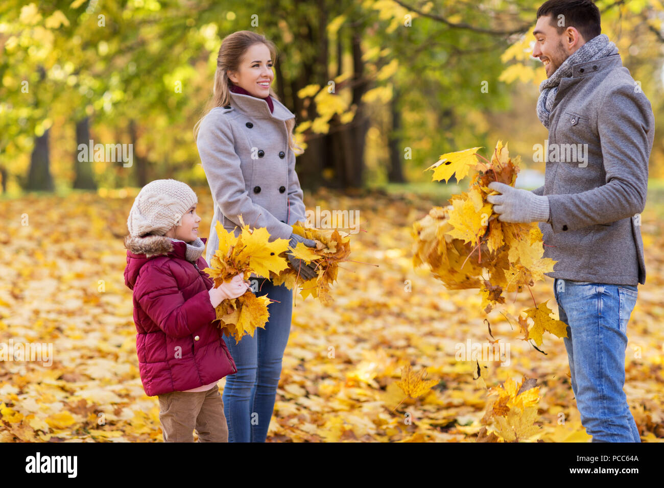happy family playing with autumn leaves at park Stock Photo - Alamy
