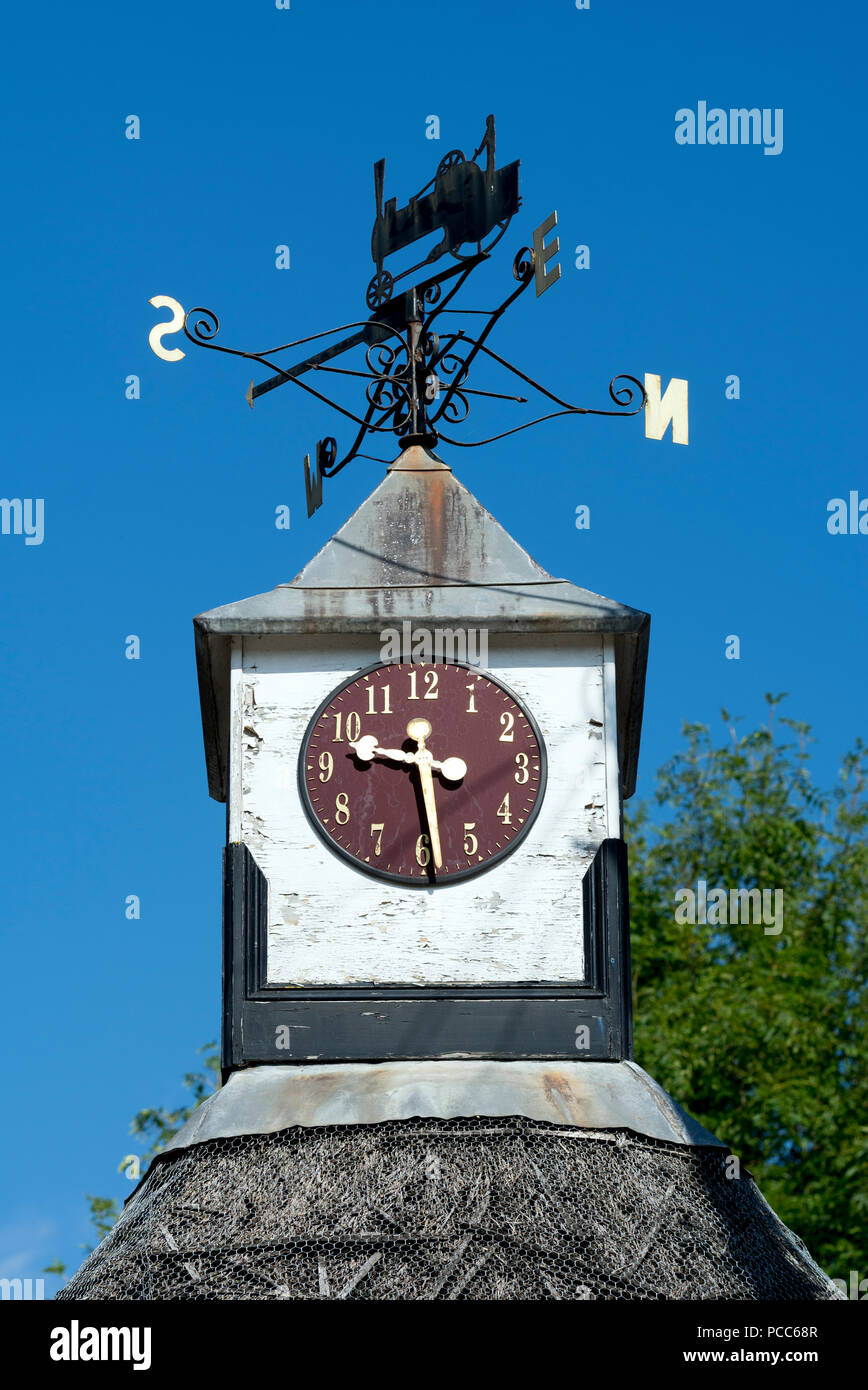 Clock and weather vane on thatched shelter, Hollowell village ...