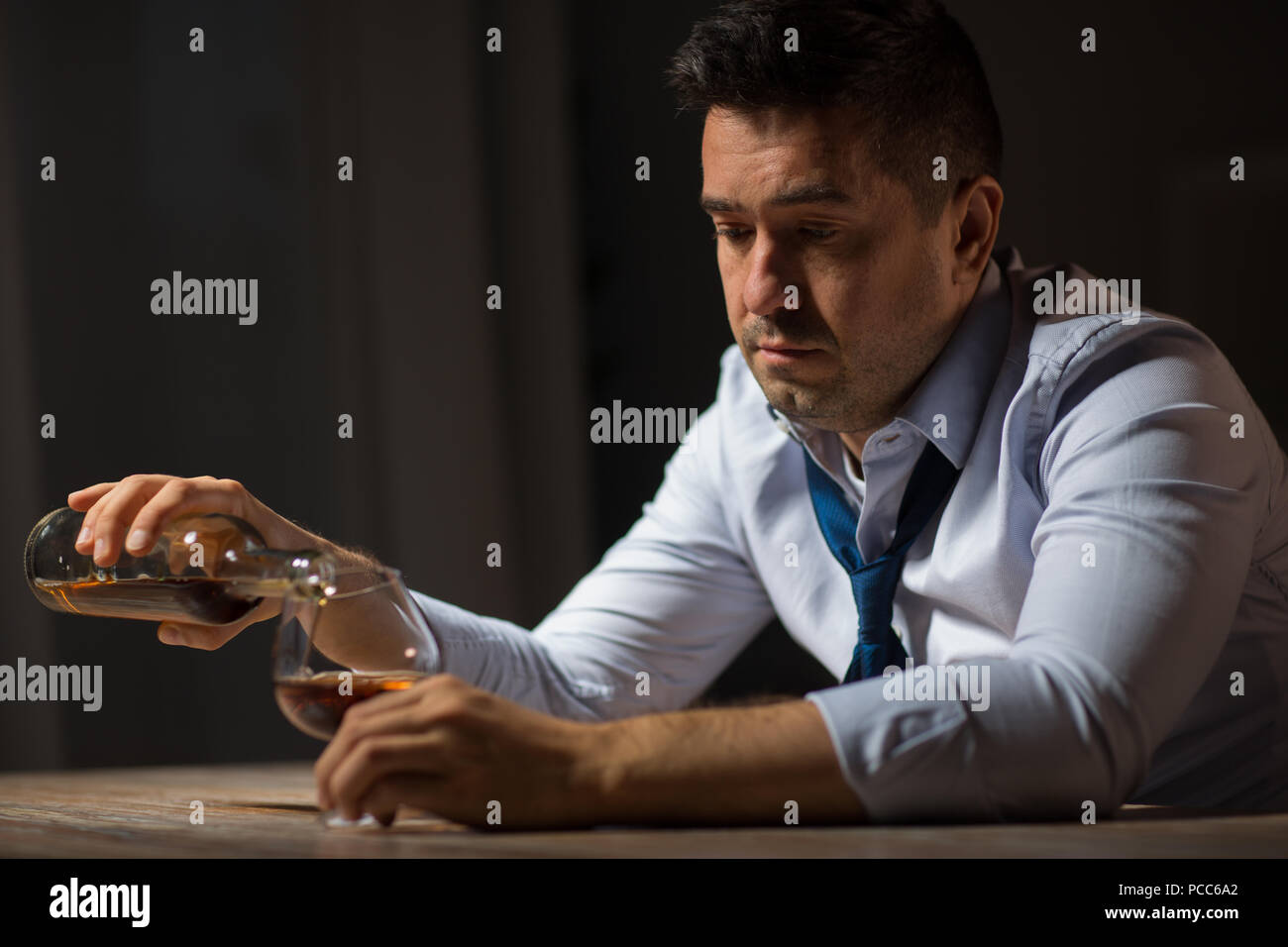 drunk man drinking alcohol at table at night Stock Photo - Alamy