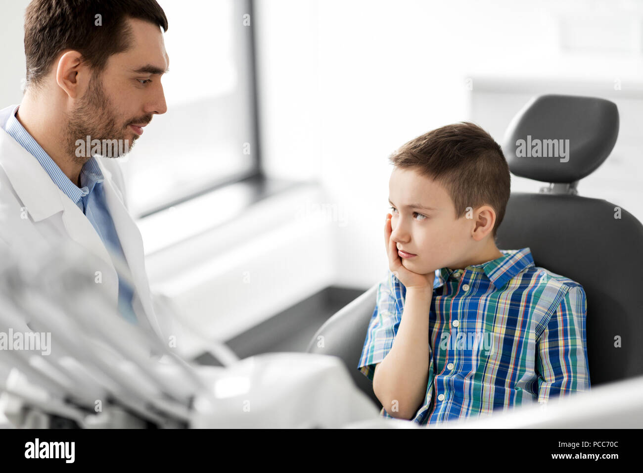 dentist with patient having toothache at clinic Stock Photo - Alamy