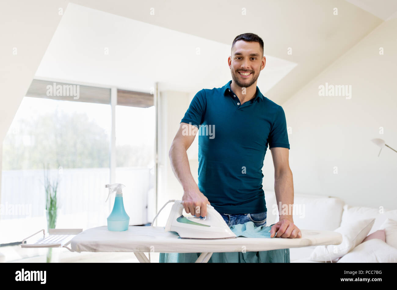 smiling man ironing shirt by iron at home Stock Photo - Alamy