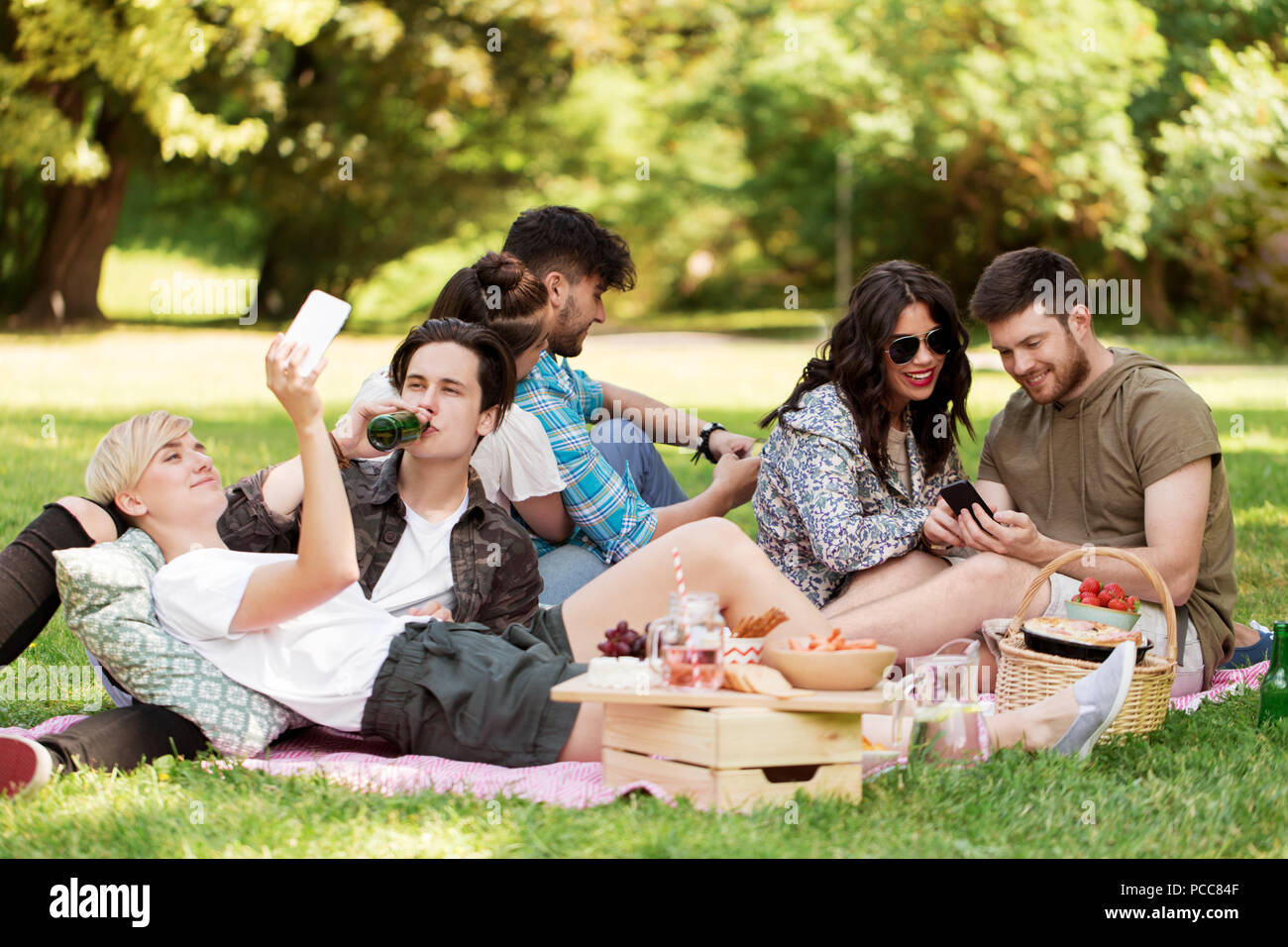 friends with smartphones on picnic at summer park Stock Photo - Alamy