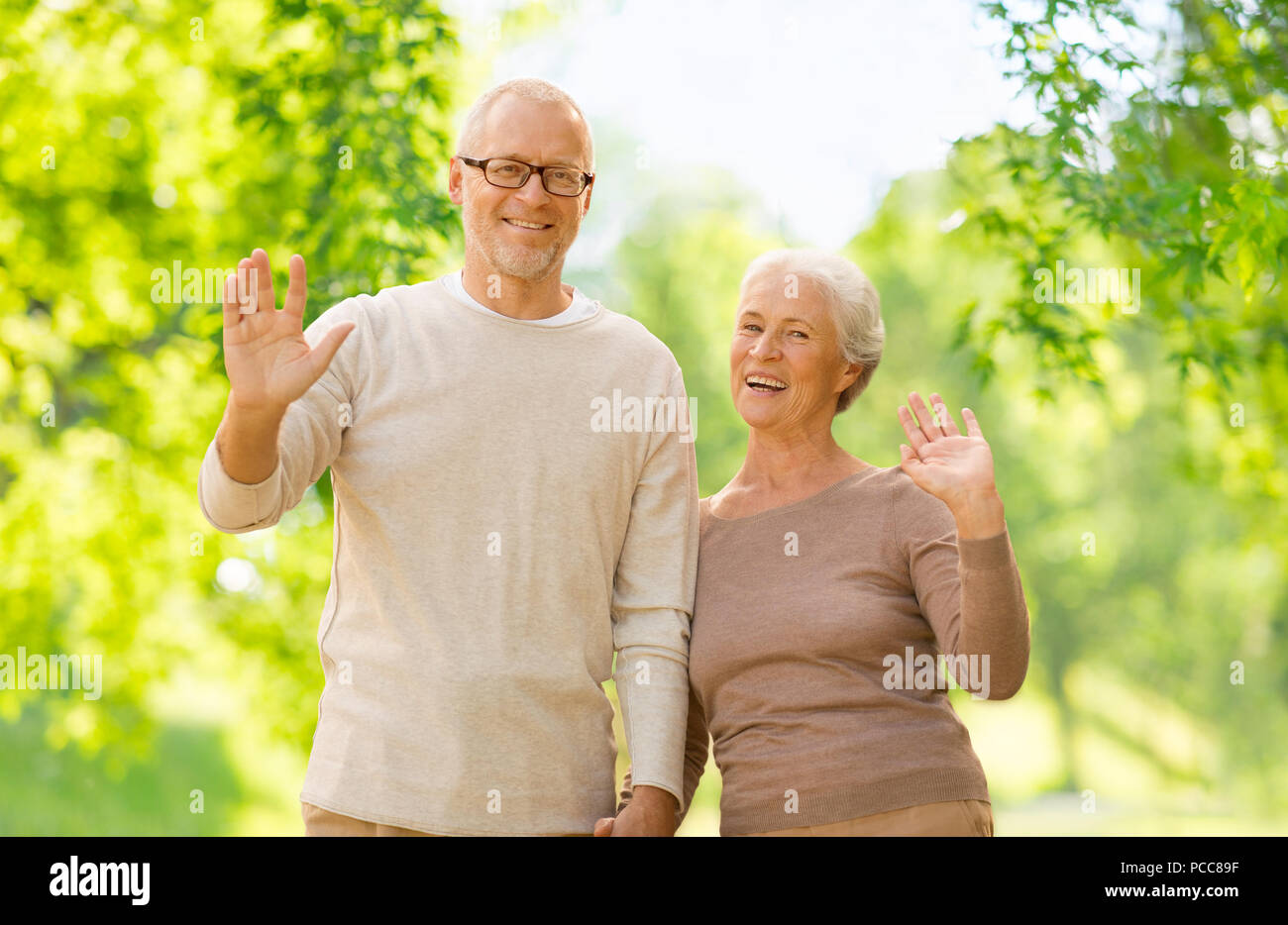 senior couple waving hands over natural background Stock Photo - Alamy