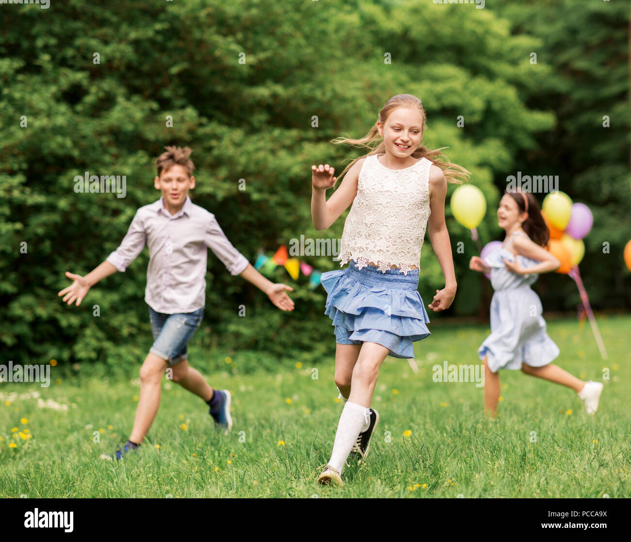 happy kids playing tag game at birthday party Stock Photo - Alamy