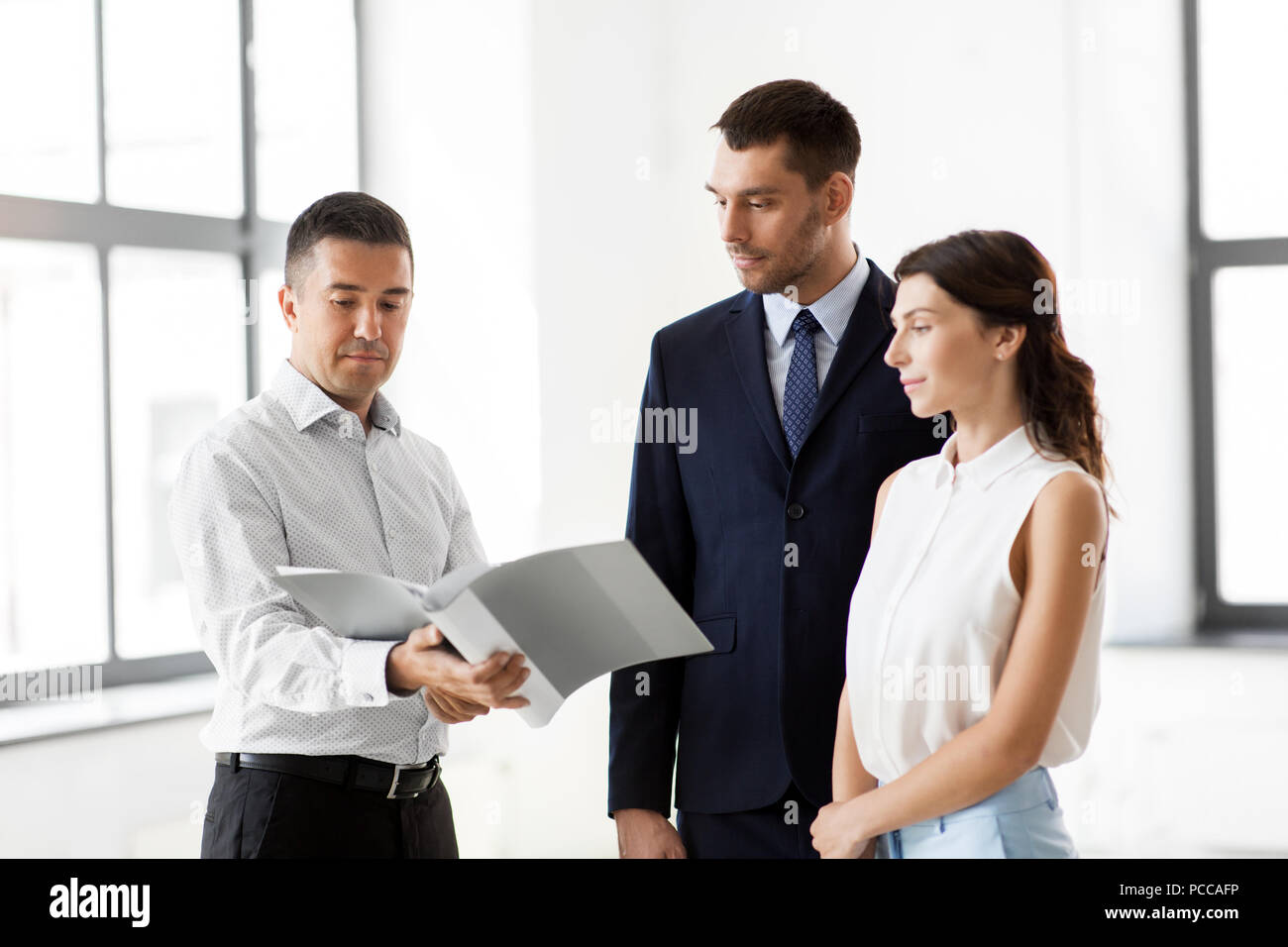 realtor with folder showing documents to customers Stock Photo - Alamy