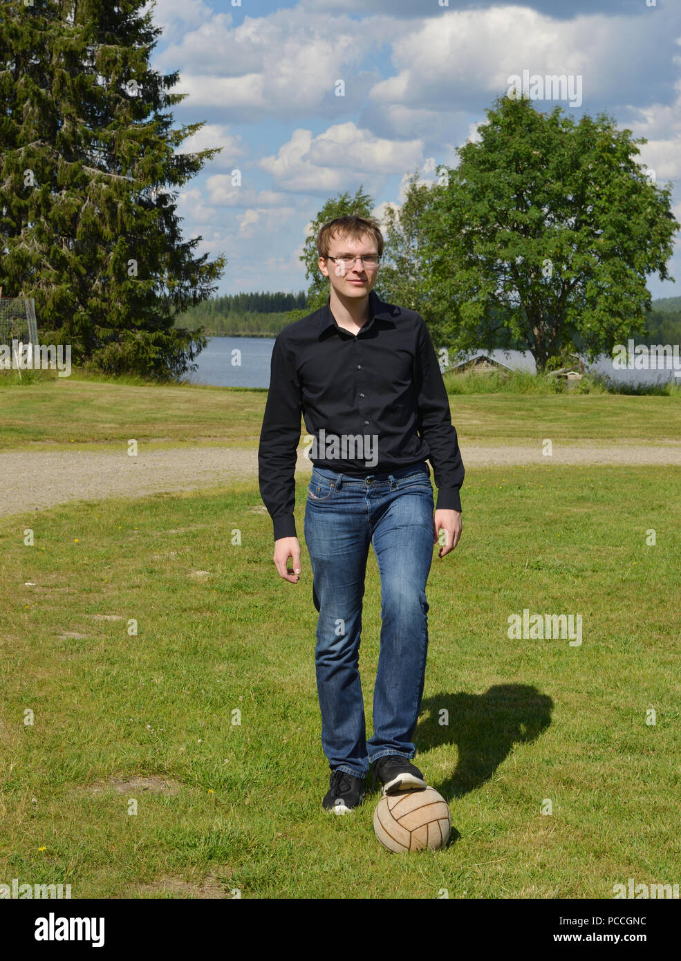 Football on green glade. Young man with ball Stock Photo - Alamy