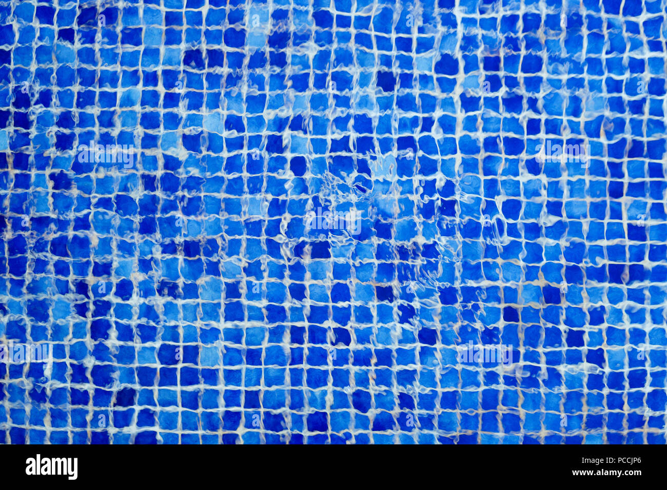 Abstract texture of blue pool mosaic bottom through the ripples of ...