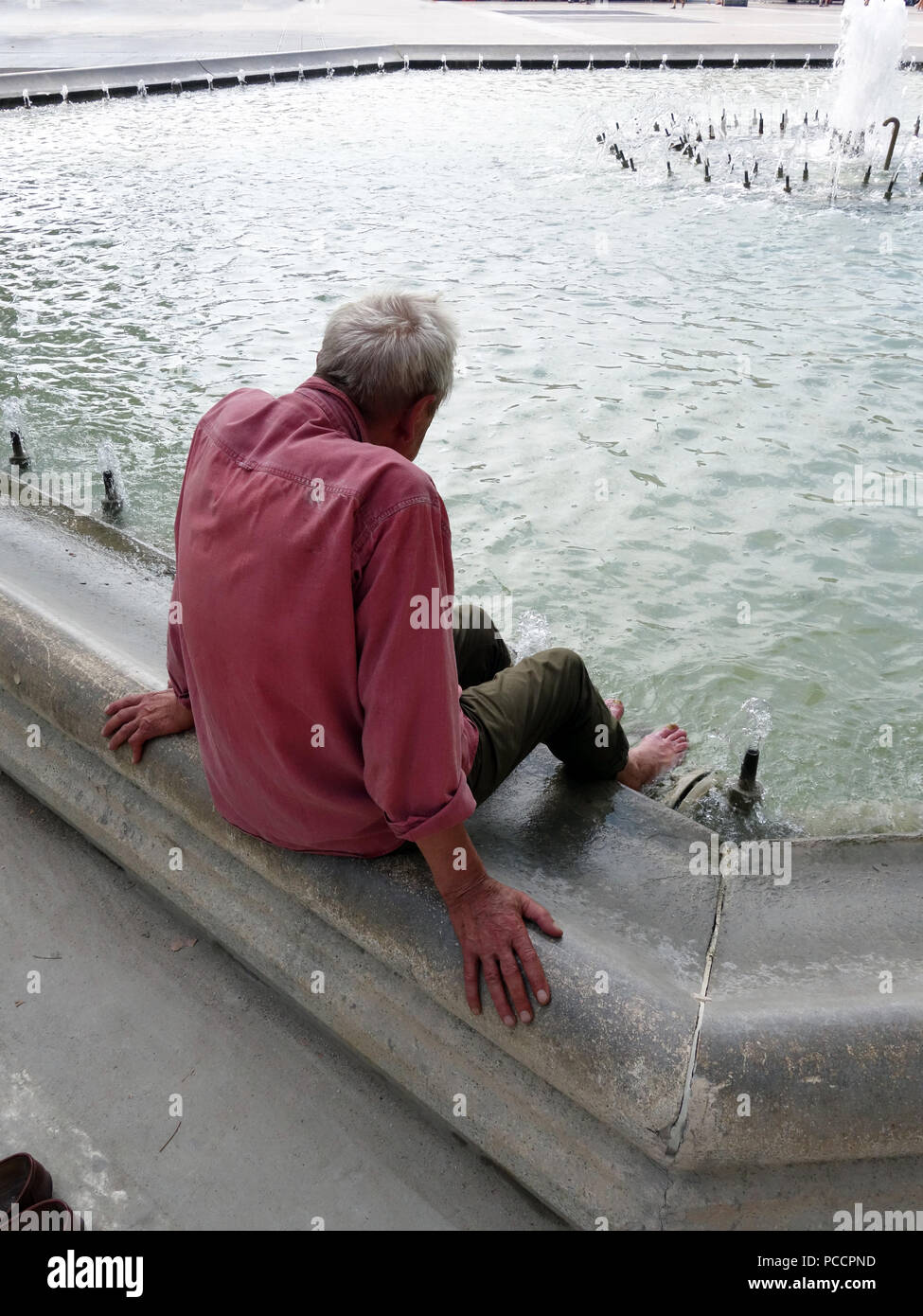 old man feeling hot and uncomfortable in the heatwave tries to keep ...