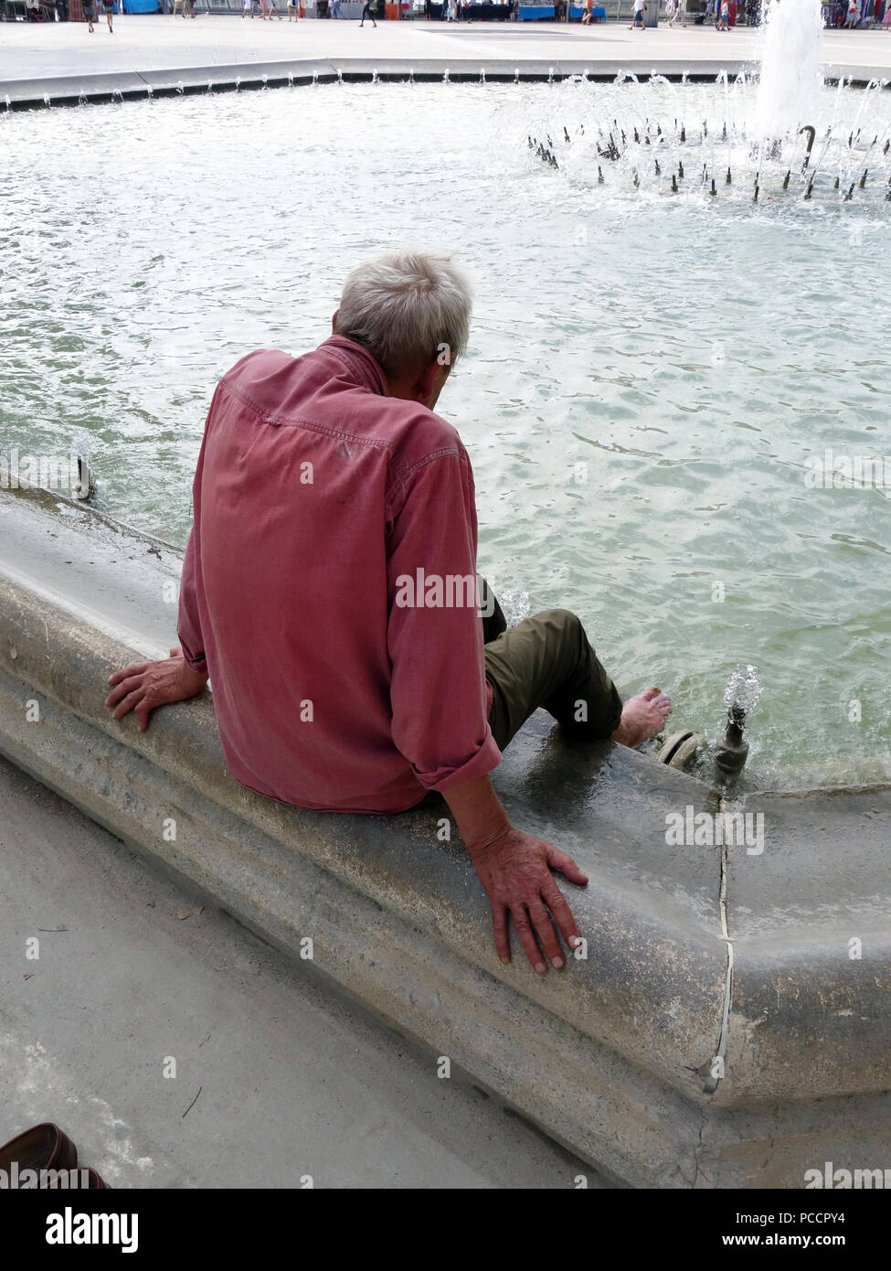 old man feeling hot and uncomfortable in the heatwave tries to keep ...