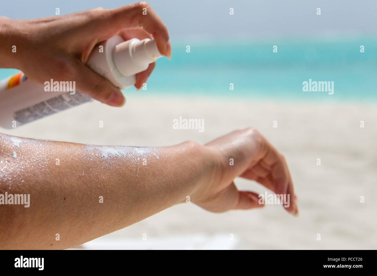 woman putting on lotion on her skin at the beach Stock Photo - Alamy