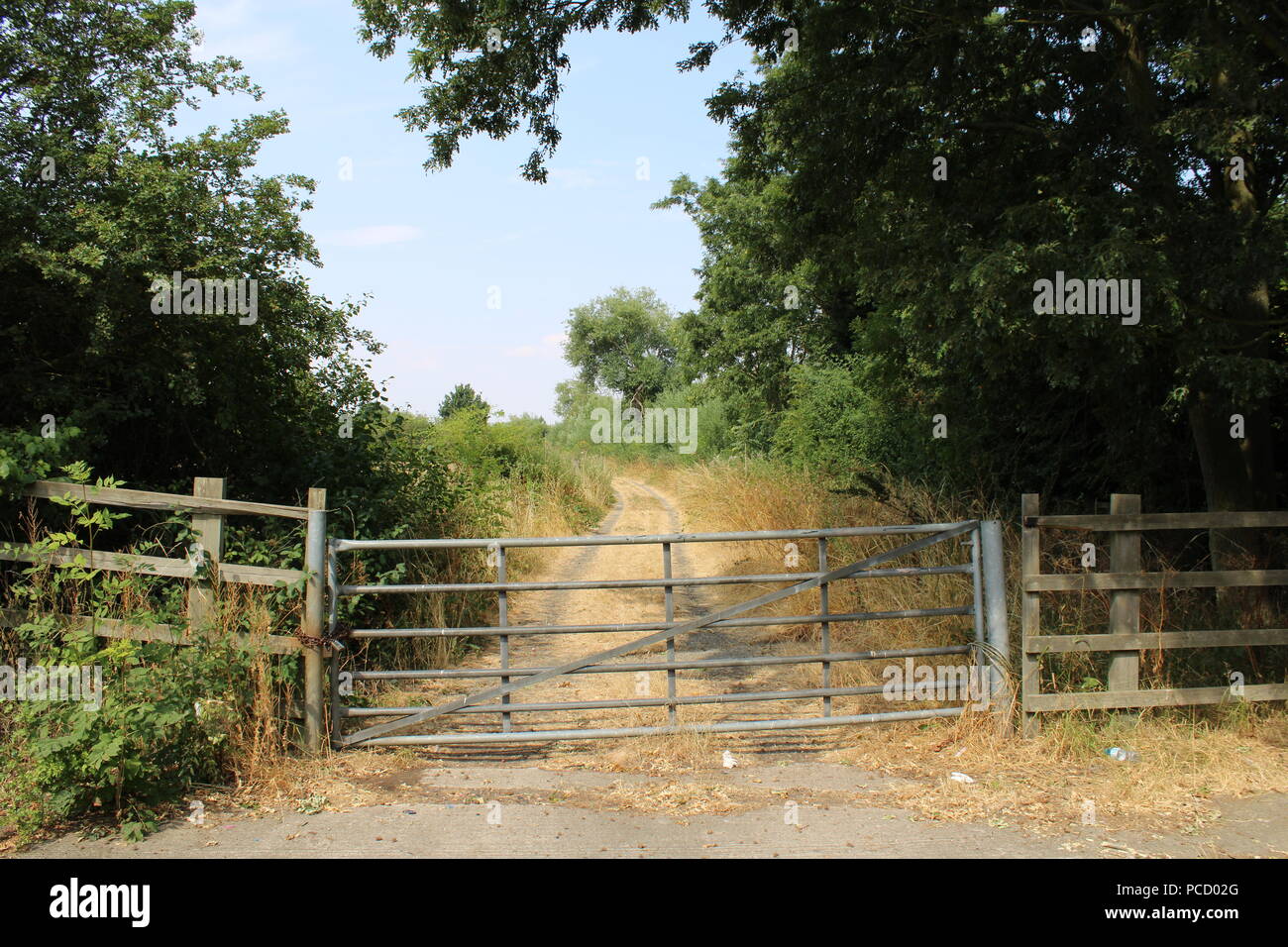 Boundary fence leading to rural track Stock Photo - Alamy