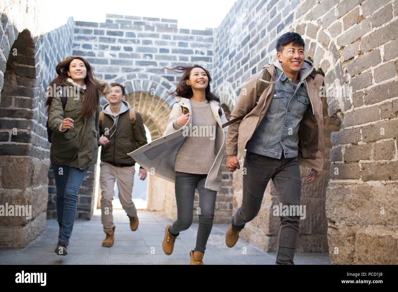 Happy young Chinese friends enjoying winter outing on the Great Wall ...