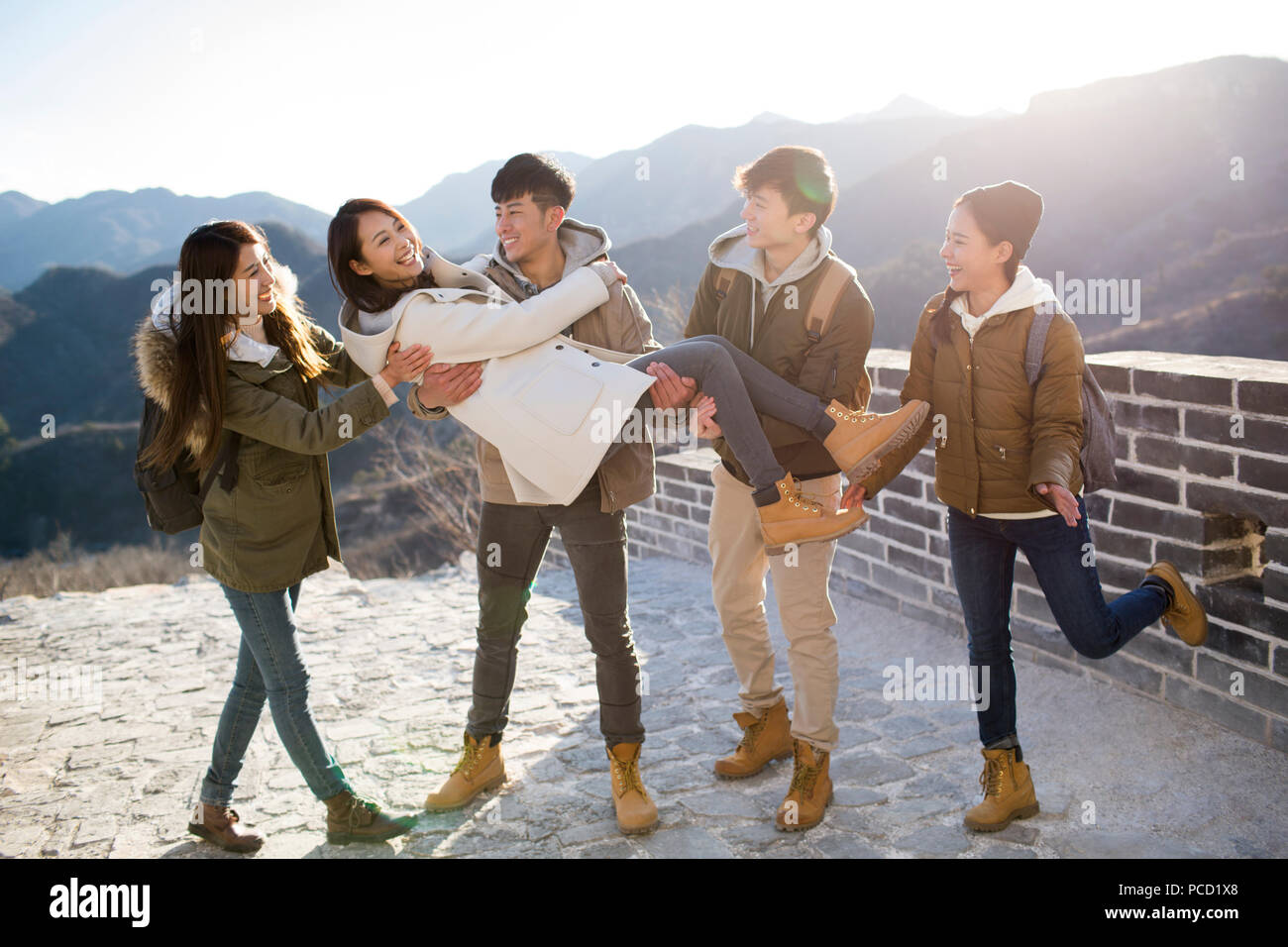 Happy young Chinese friends enjoying winter outing on the Great Wall ...