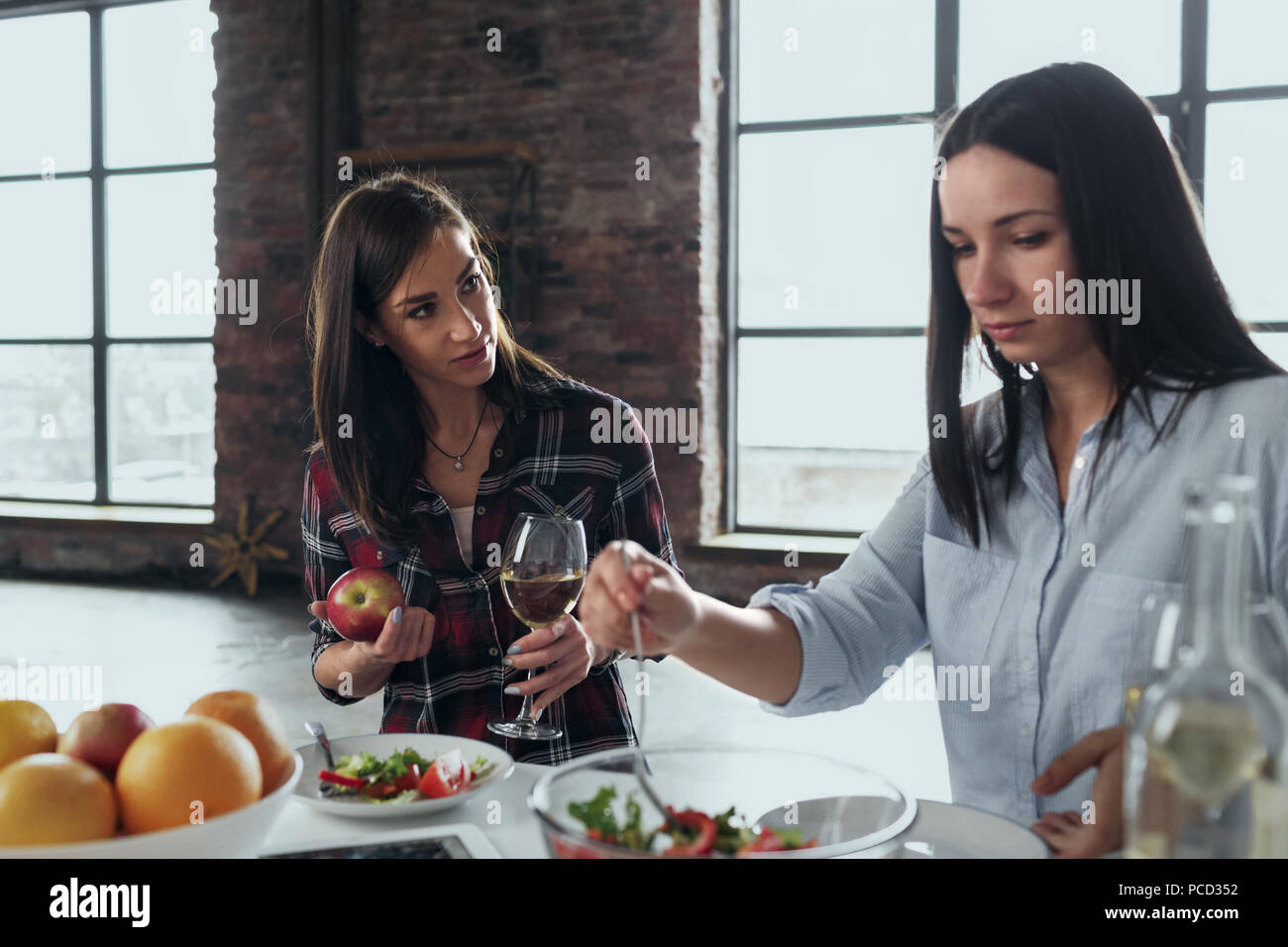 Two girlfriends home sitting table hi-res stock photography and images ...