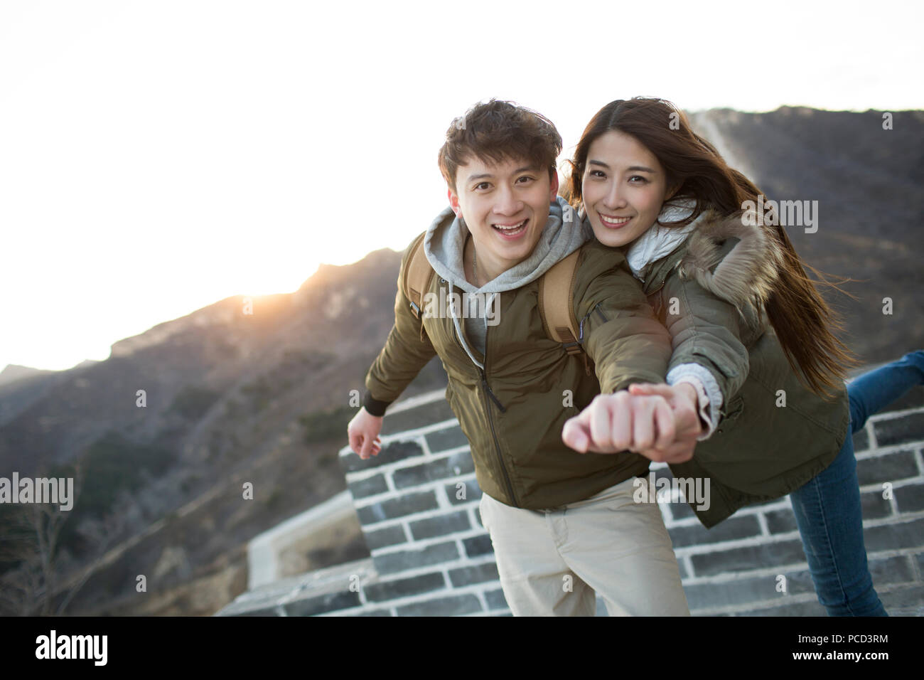 Happy young Chinese couple enjoying winter outing on the Great Wall Stock Photo - Alamy
